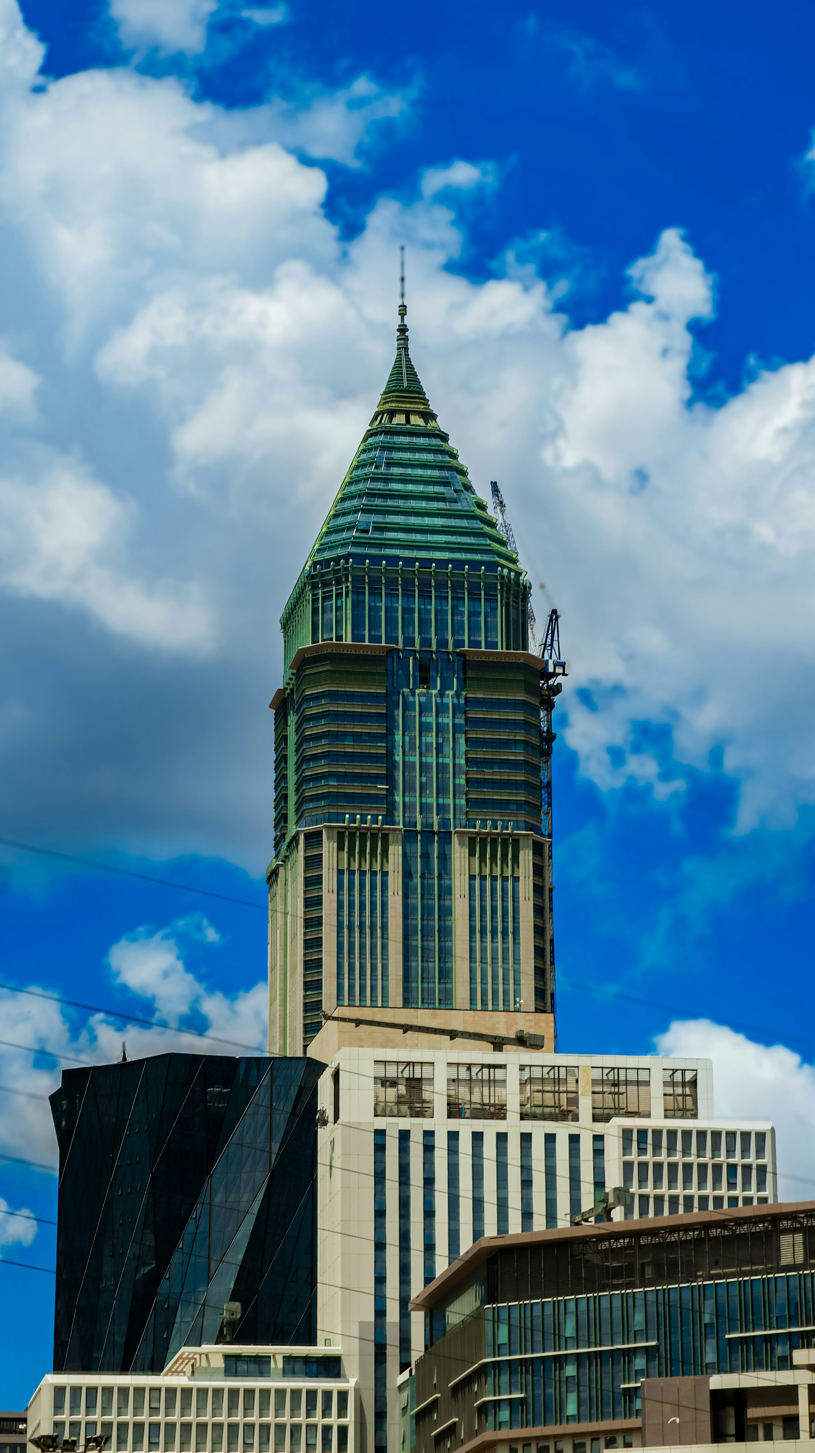 Emerald Spire Rising: A Glass-Capped Tower Piercing the City Sky