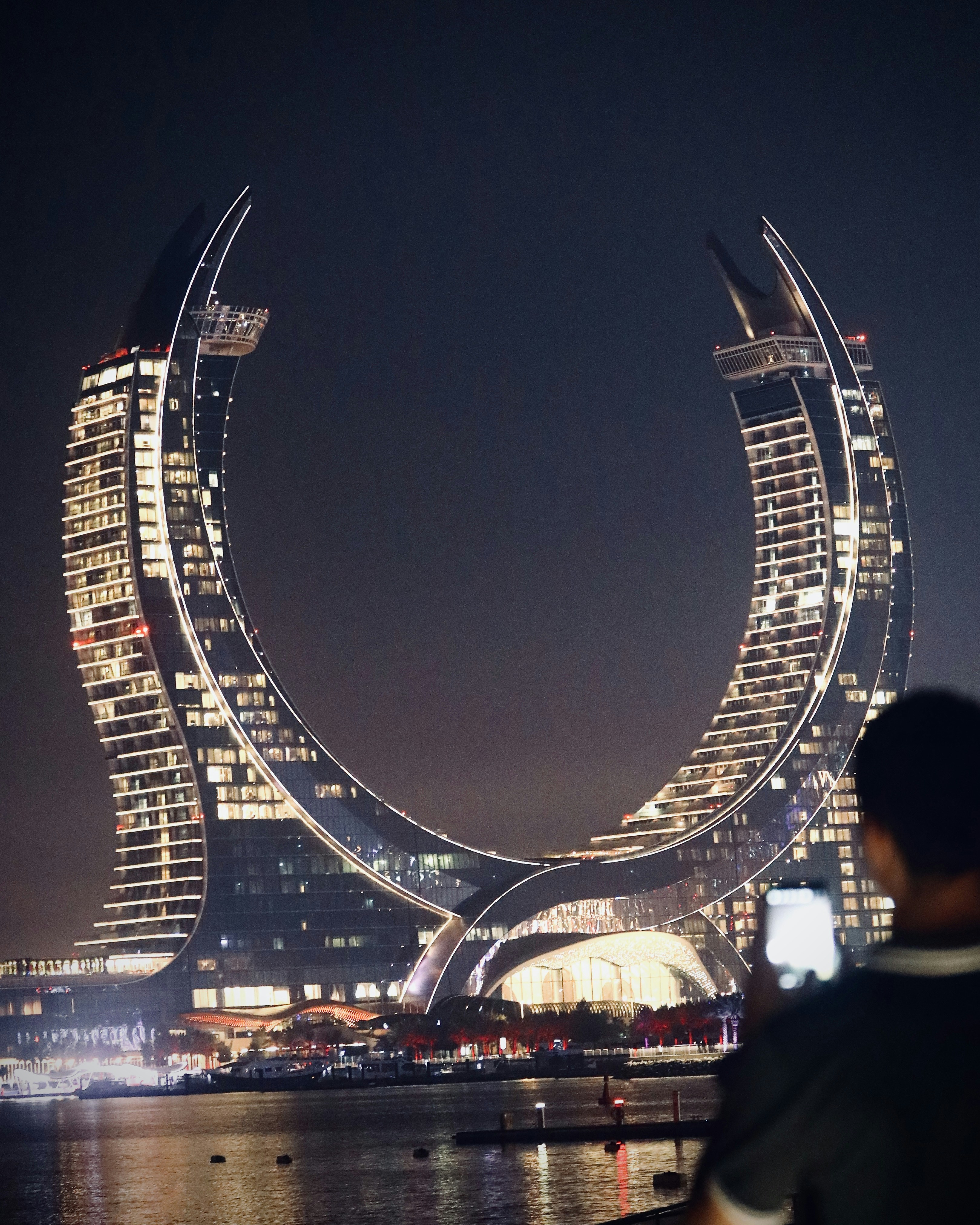 A man is taking a picture of a futuristic building photo – Free ...