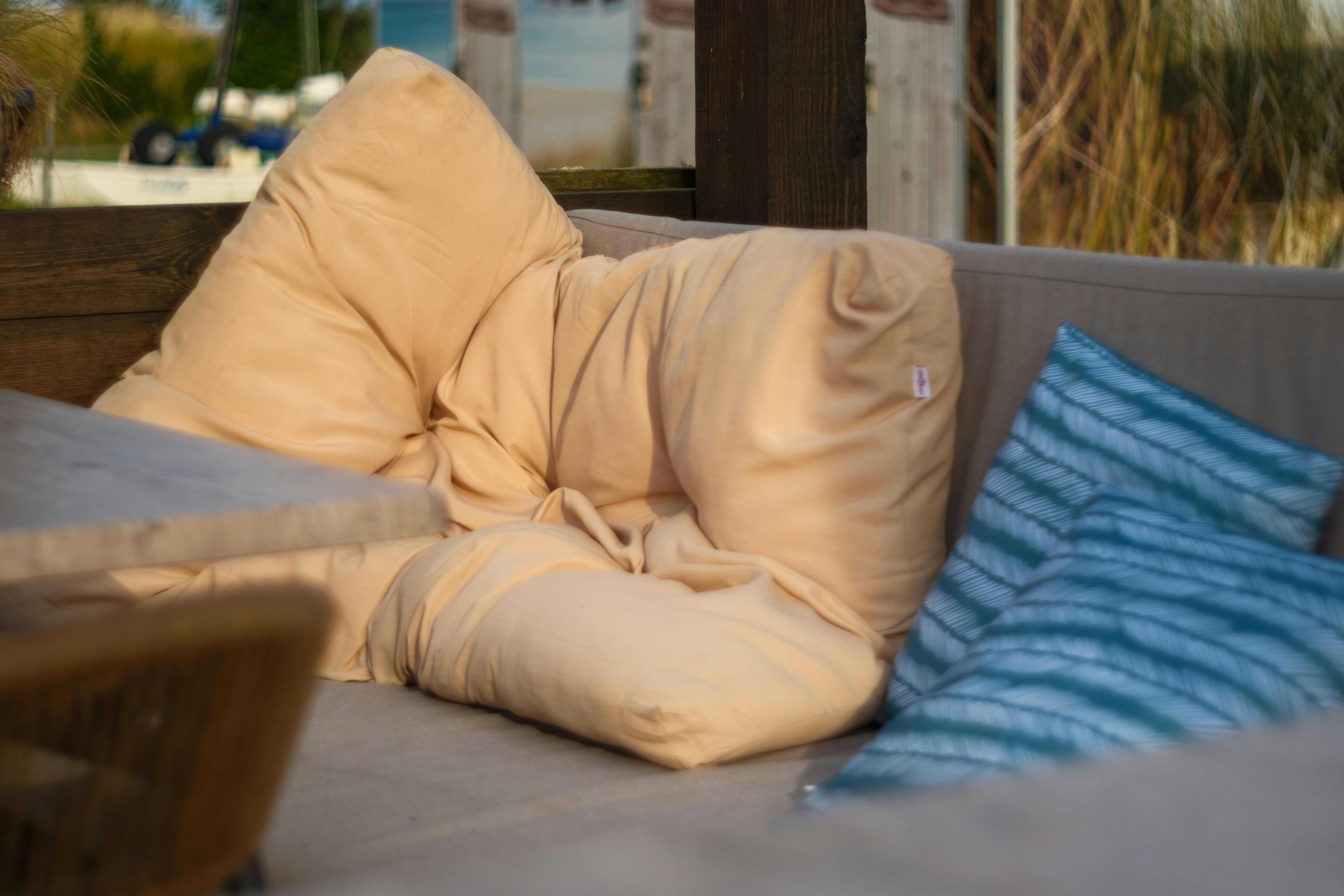 Soft-Edge Oasis: Beige Cushions on a Sunlit Patio Lounge