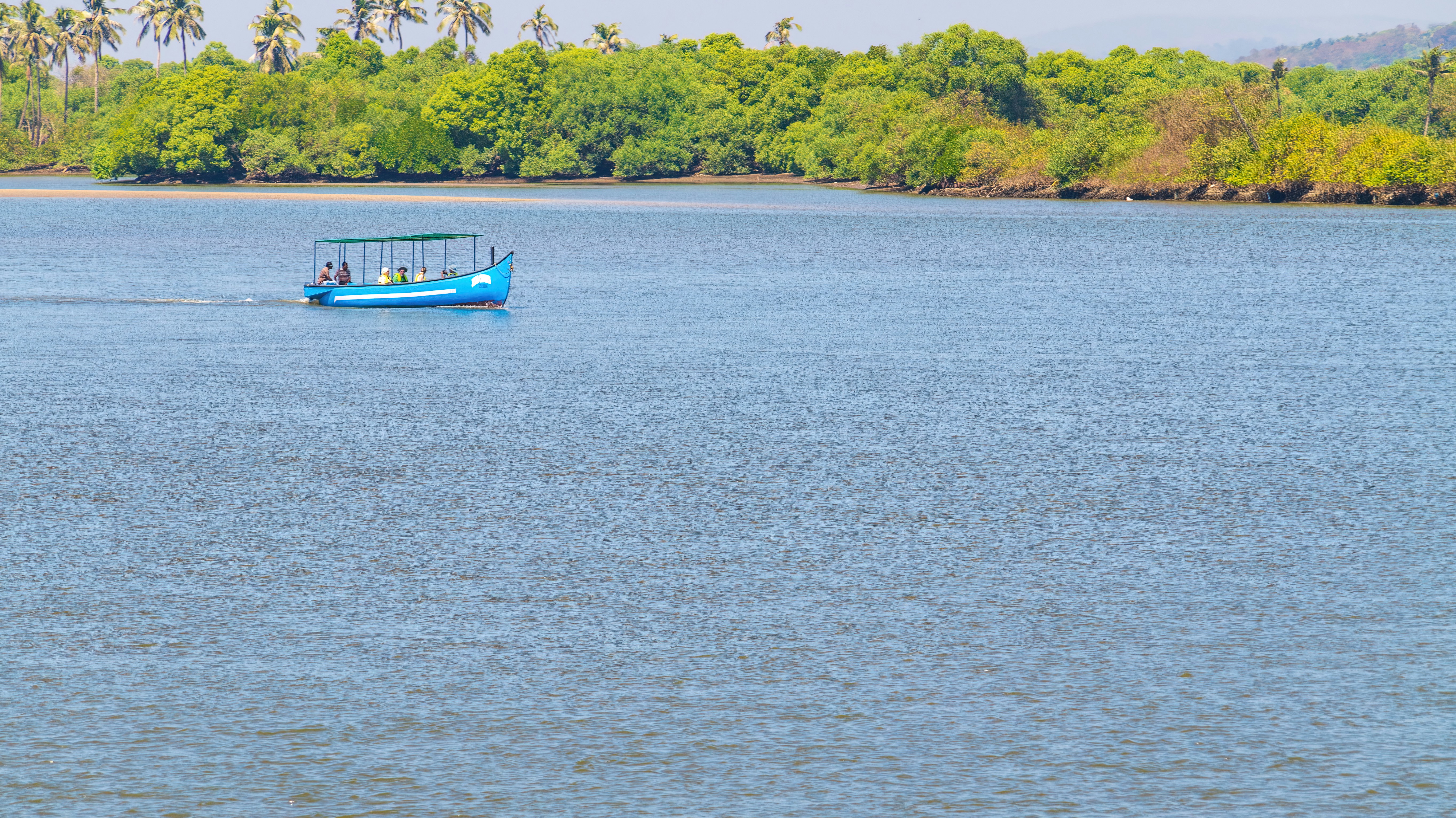 A blue boat floating on top of a large body of water photo – Free ...