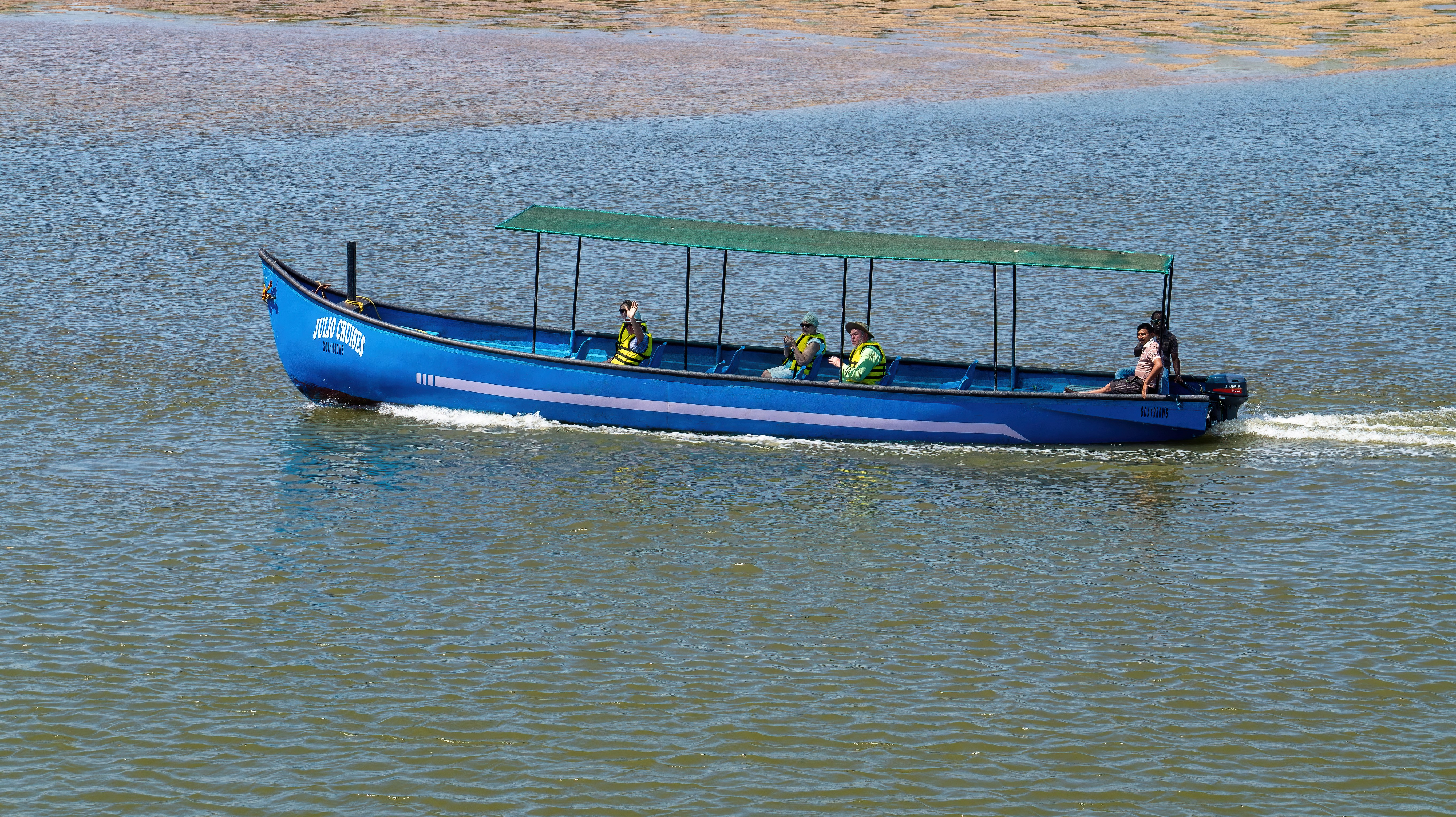 A blue boat with people in it on a body of water photo – Free Human ...