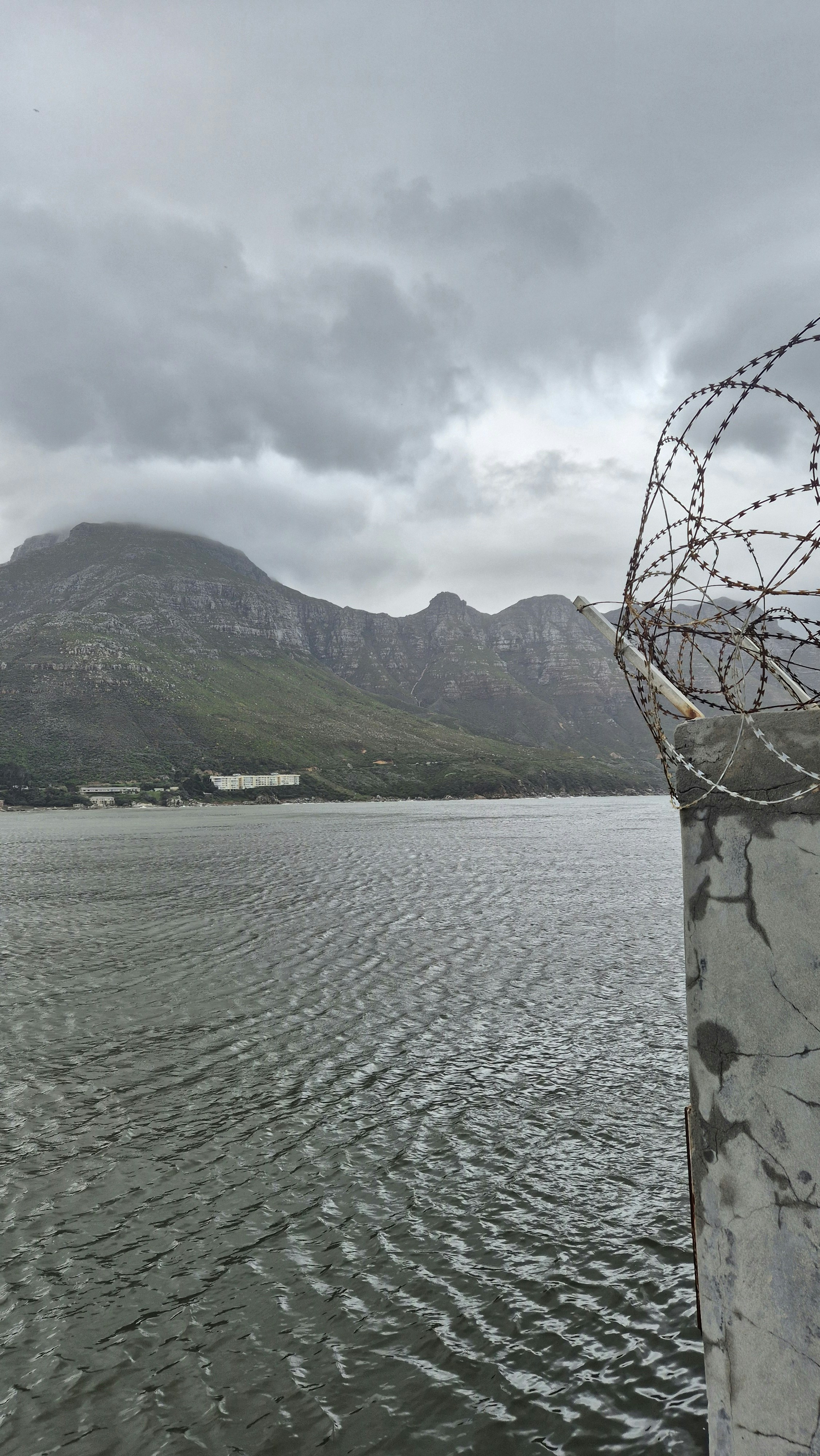 Barbed Curtain Over a Cloudy Coastal Ridge