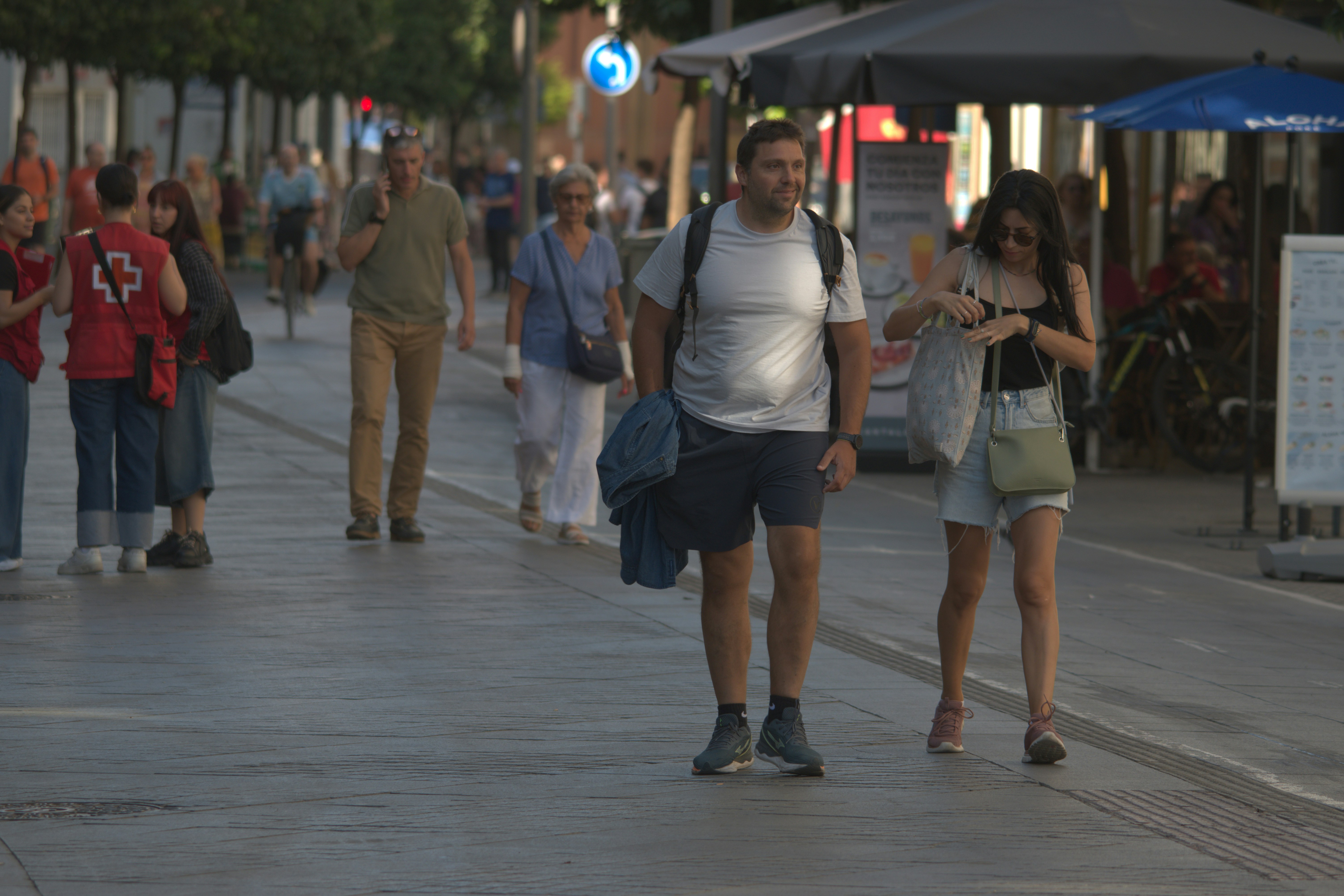 A group of people walking down a sidewalk photo – Free Woman Image on ...