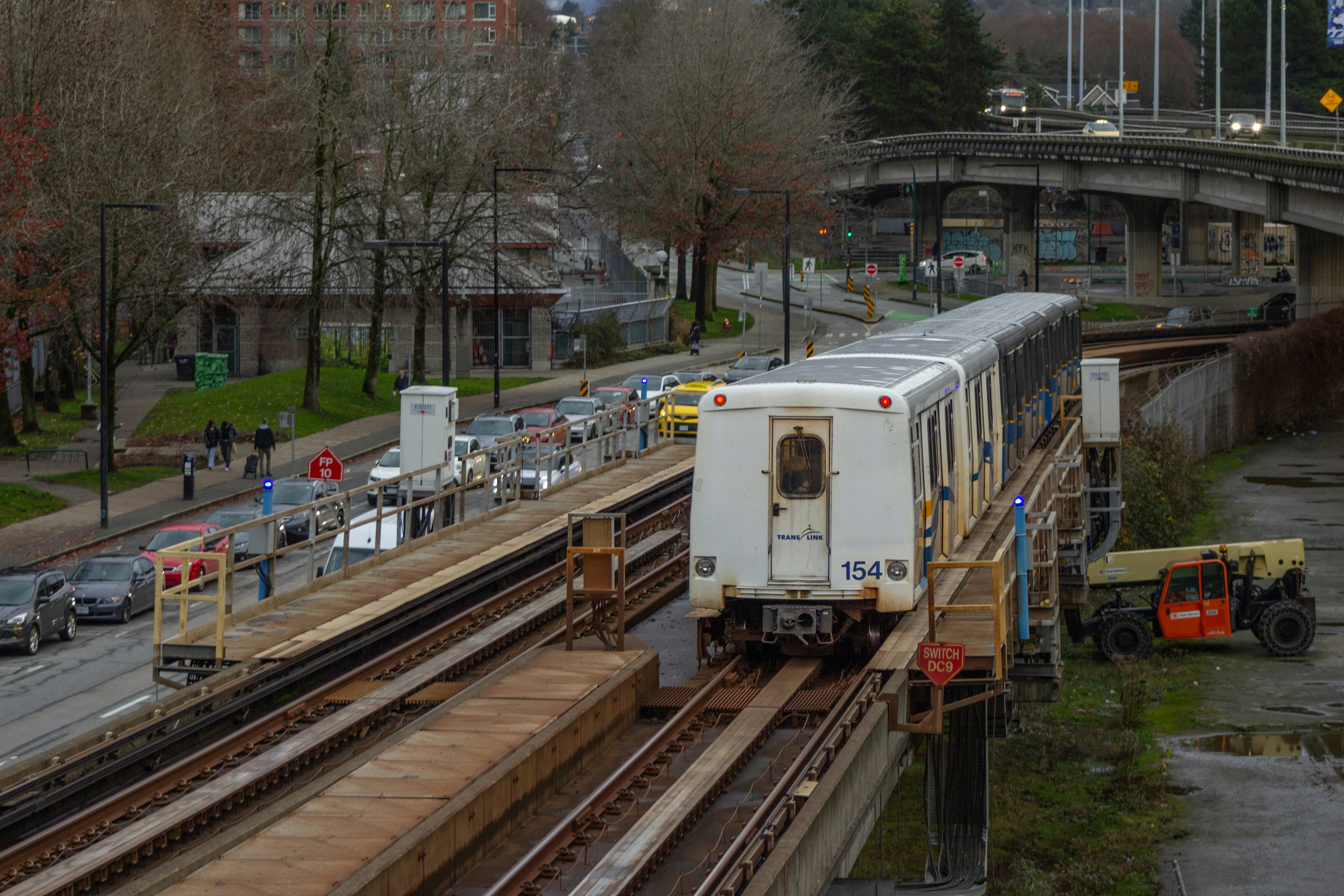A train traveling down train tracks next to a bridge photo – Free ...