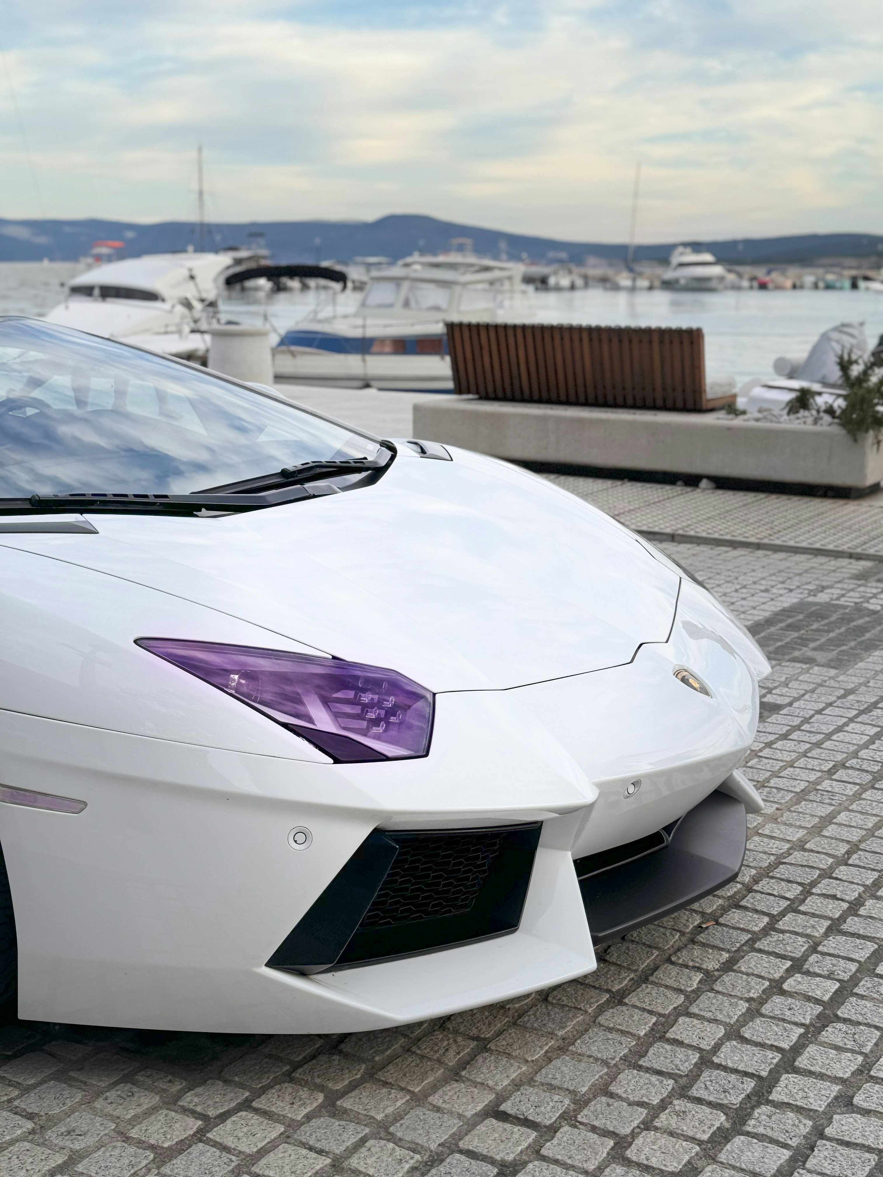Harborfront Chrome: The White Lamborghini with a Purple Headlight by the Docks