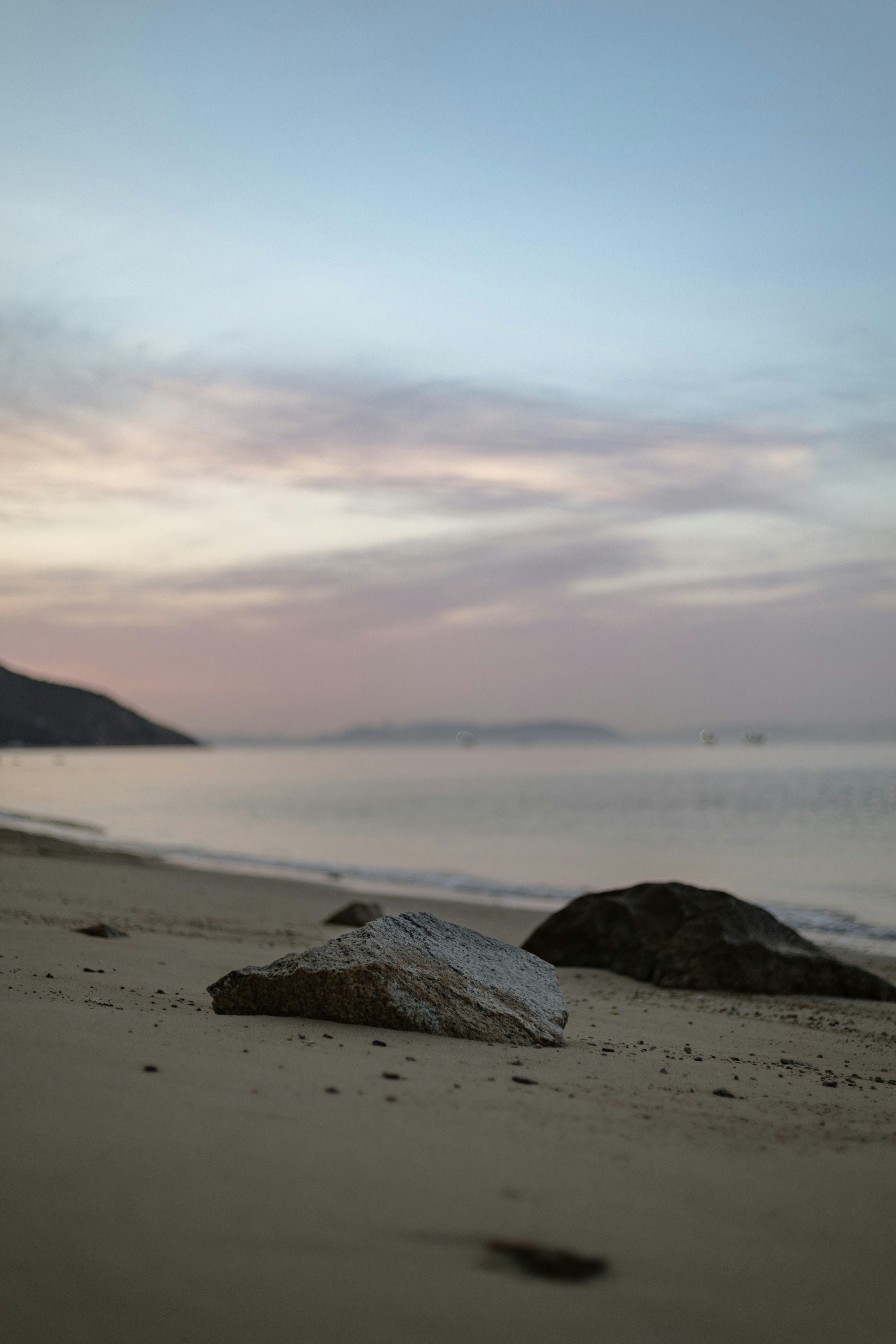 Una foto borrosa de una playa con una roca en primer plano foto ...