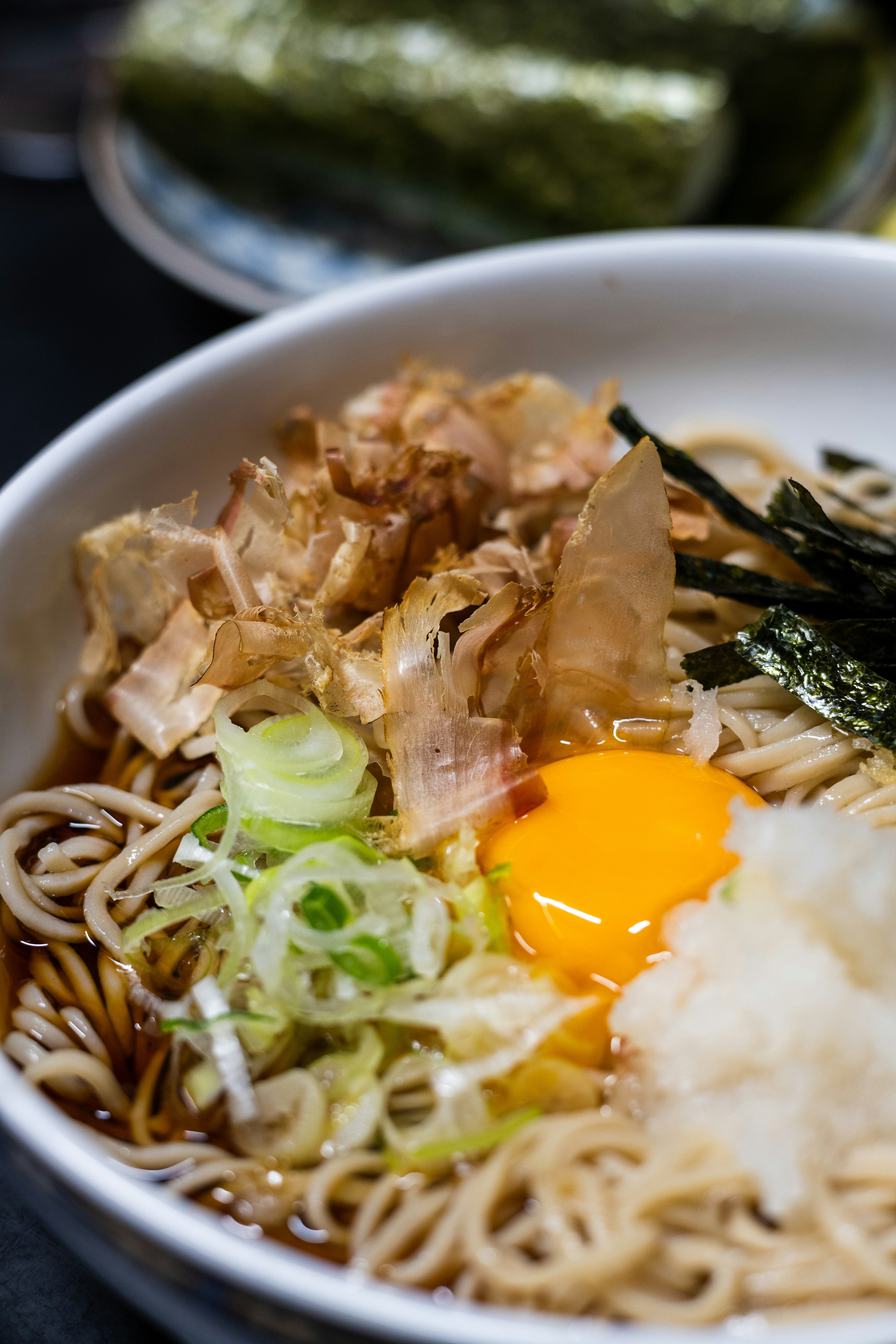 A bowl of noodles, meat, and vegetables on a table photo – Free Food ...