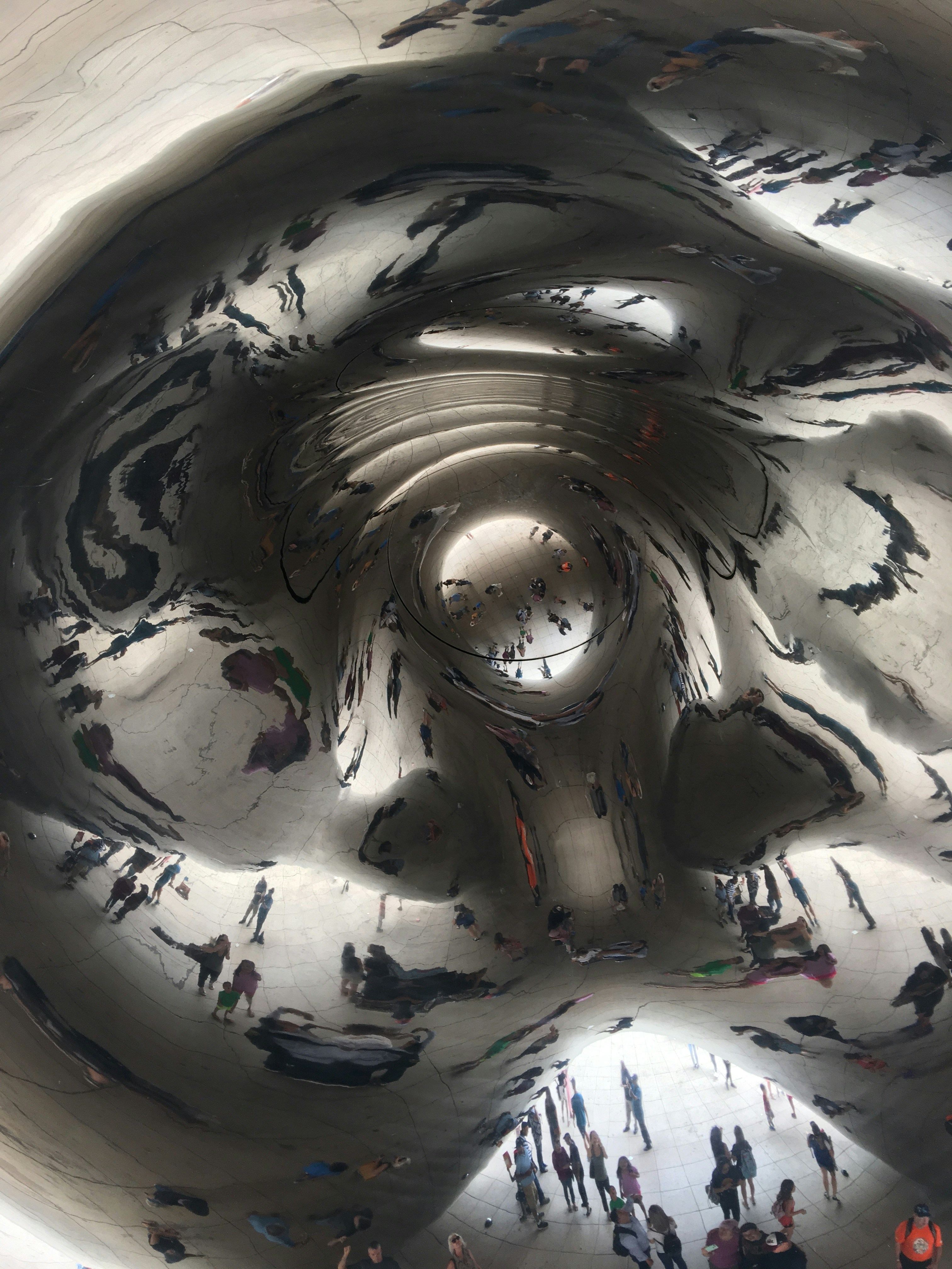 Echoes in Chrome: A Crowd Spirals Through a Curved Mirror