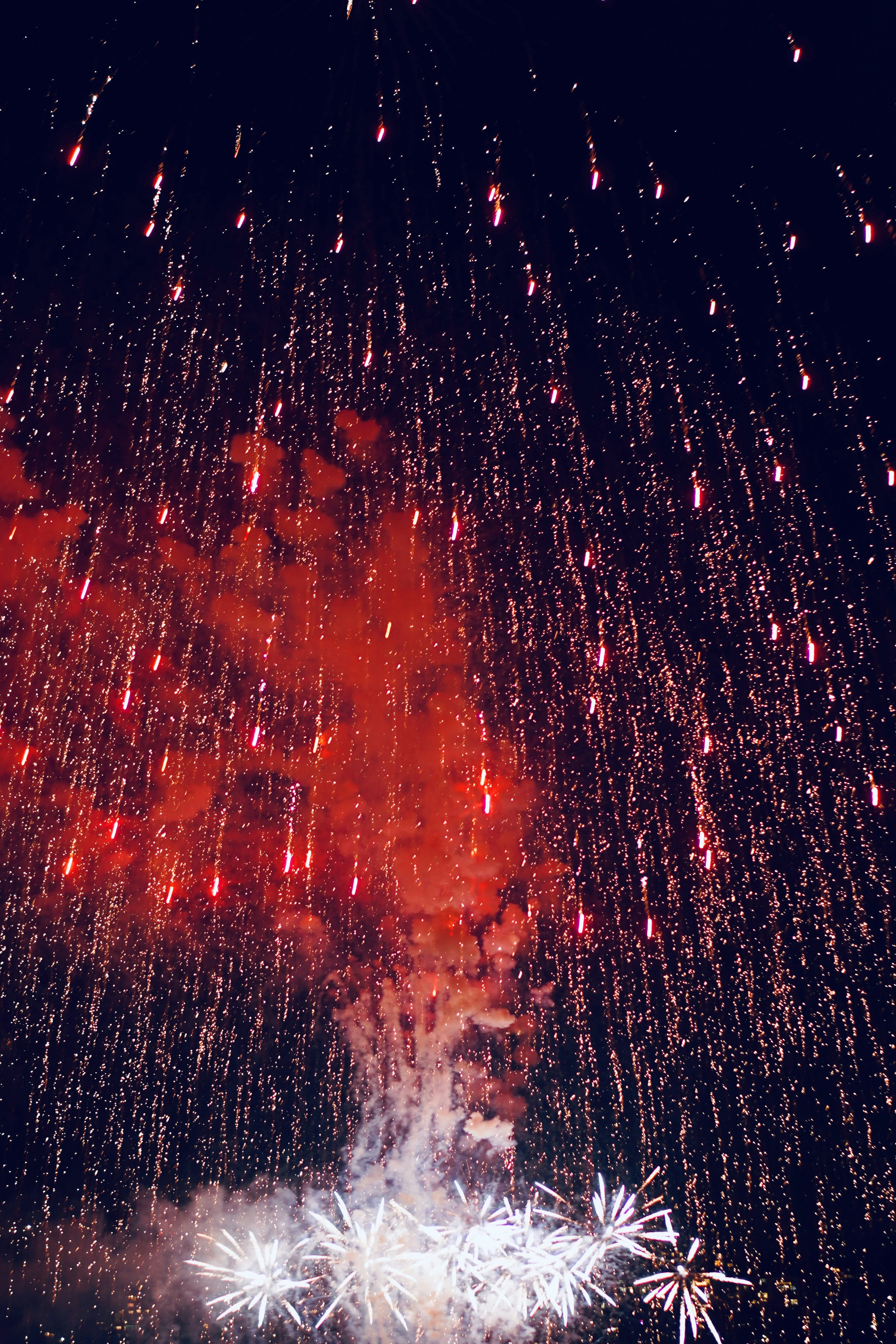 Midnight Skies Crowned with Sparks: A Firework Cascade Over a Cloud of Smoke