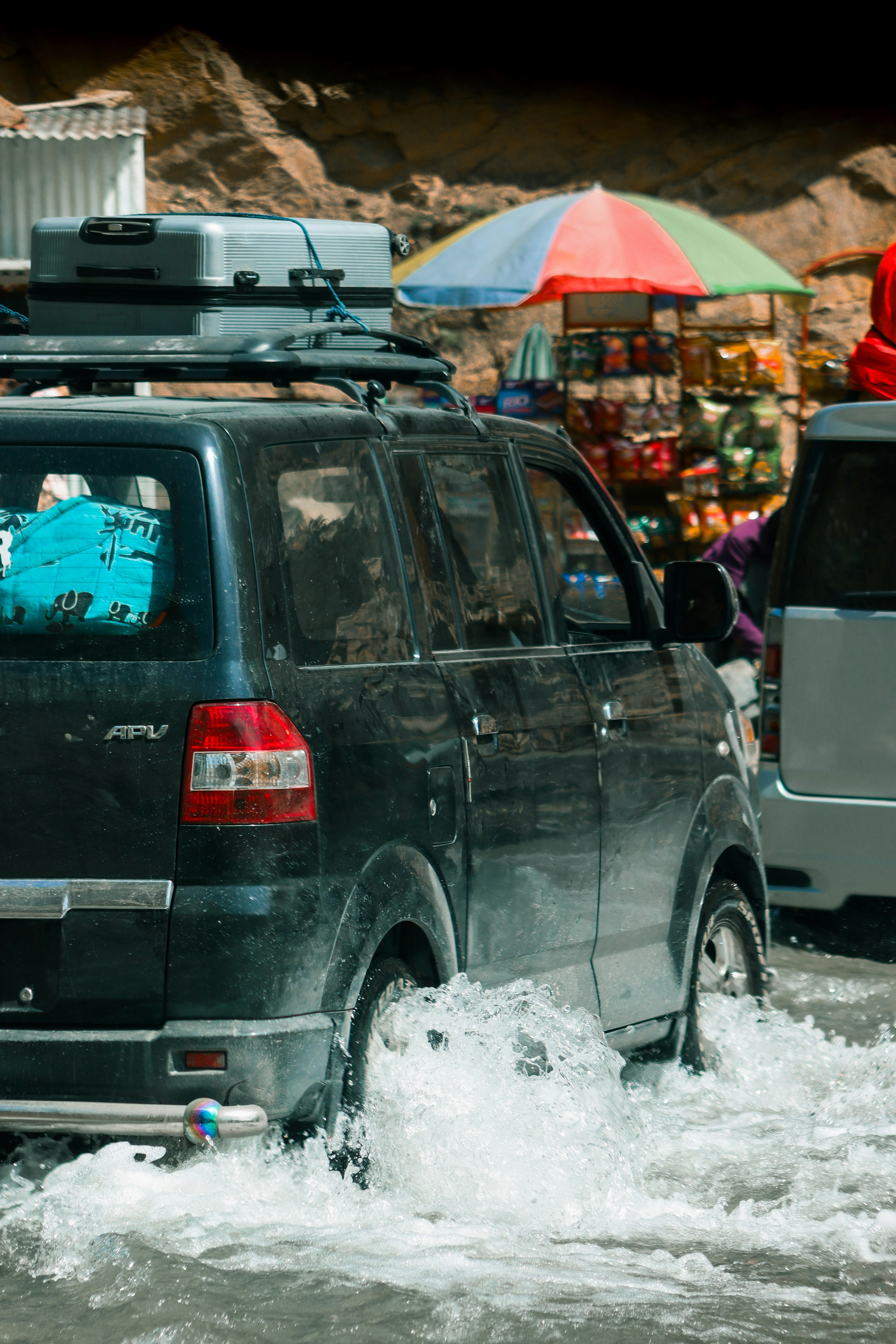 Mid-Stream Harbor: SUV Wading Through Flooded Market
