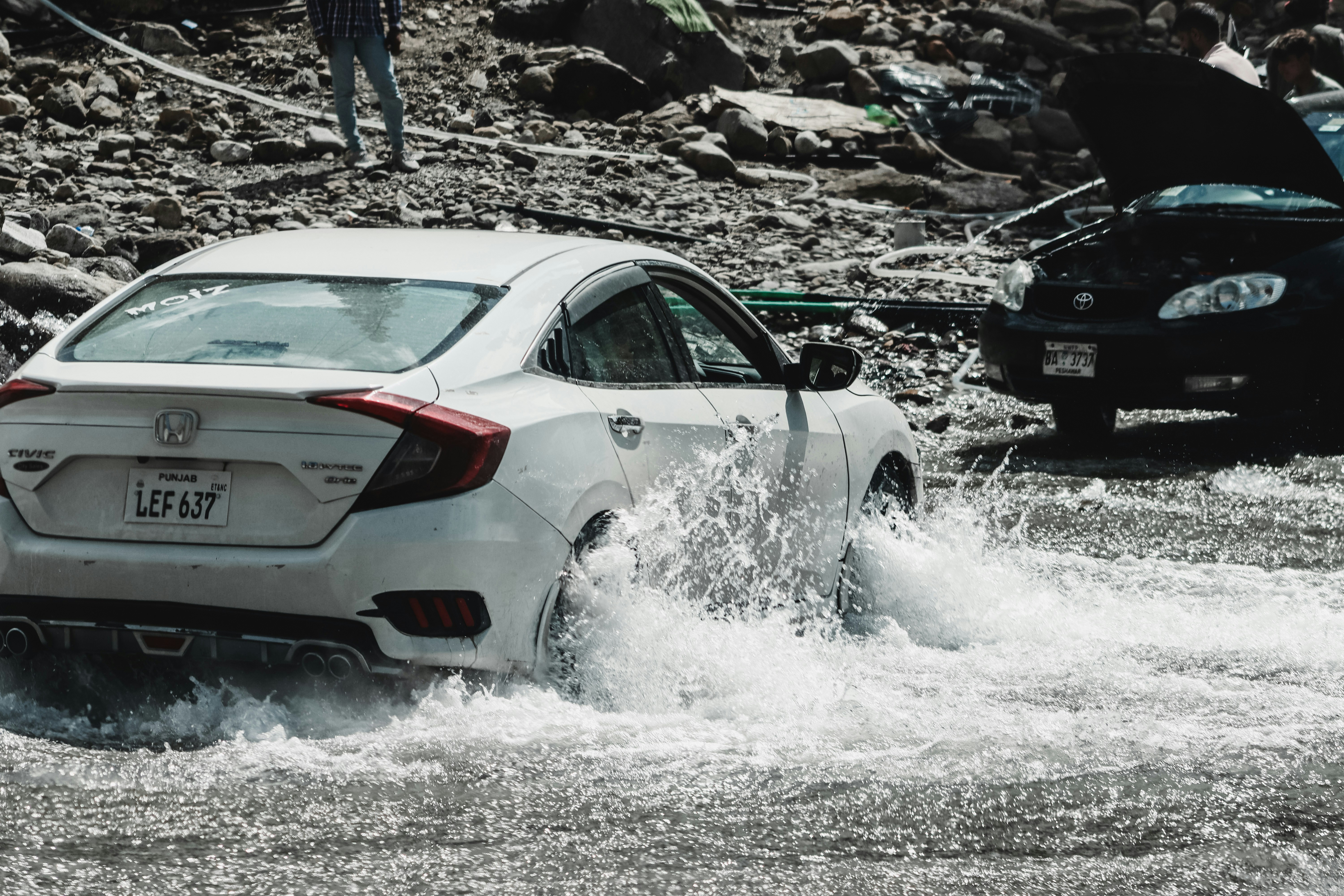 White Sedan Confronts the River: Spray-Charged Crossing