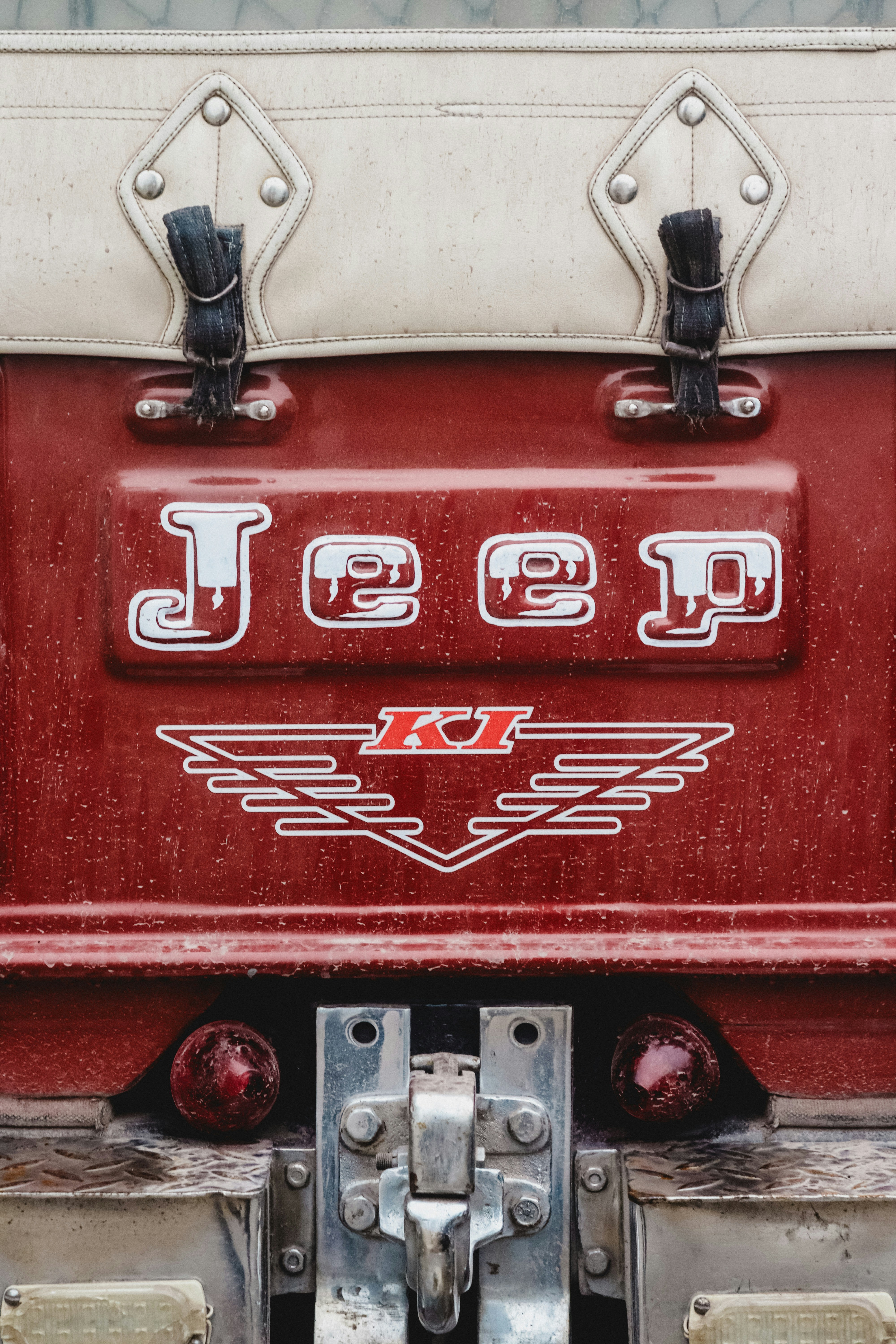 Rear Union: Vintage Jeep Emblem on a Weathered Red Trunk