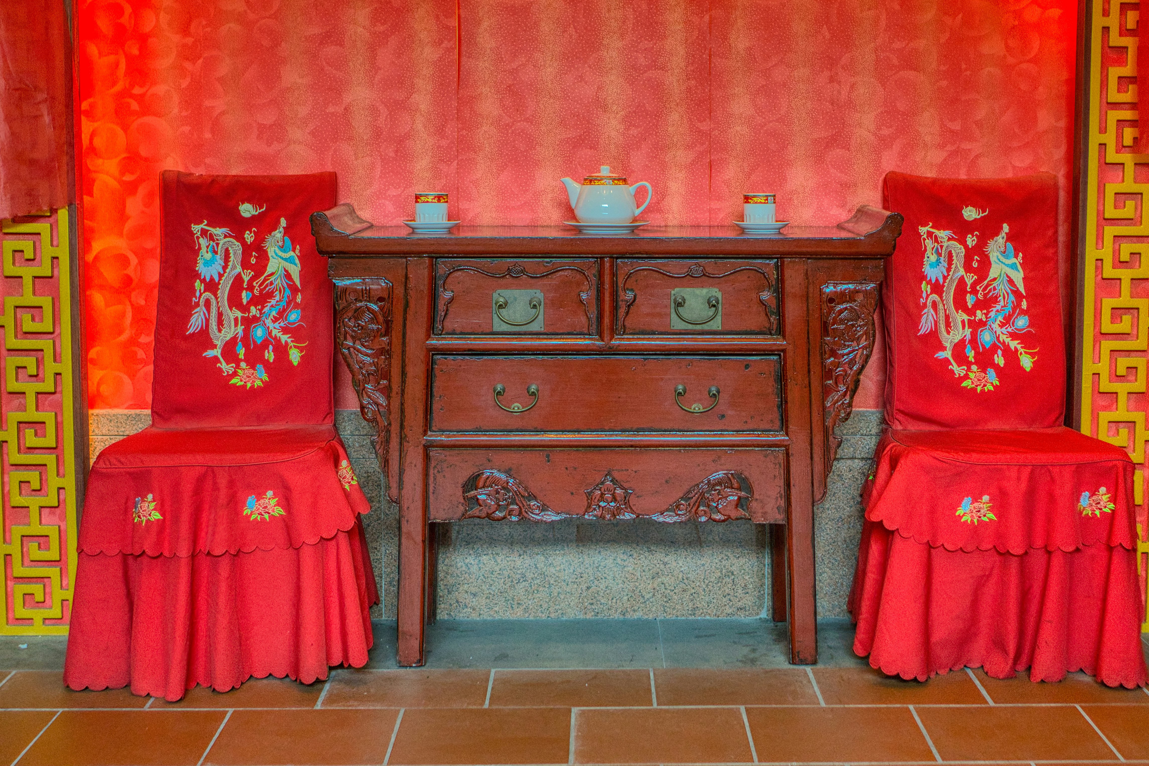 Crimson Altar Tableau: Dragon-Embroidered Chairs Framing a Carved Console