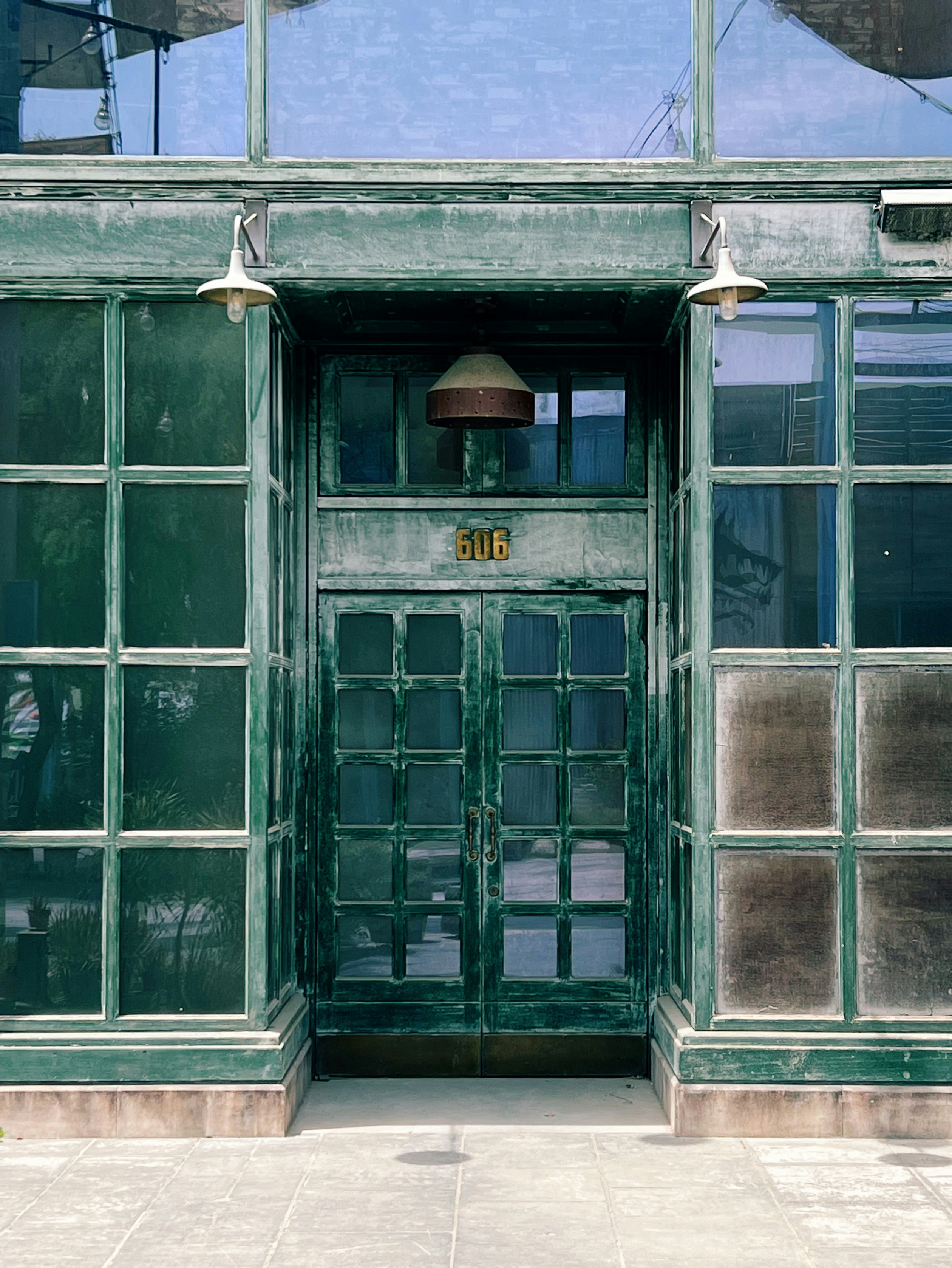 606 Green Glass Doorway: Symmetry Amid Weathered Facade