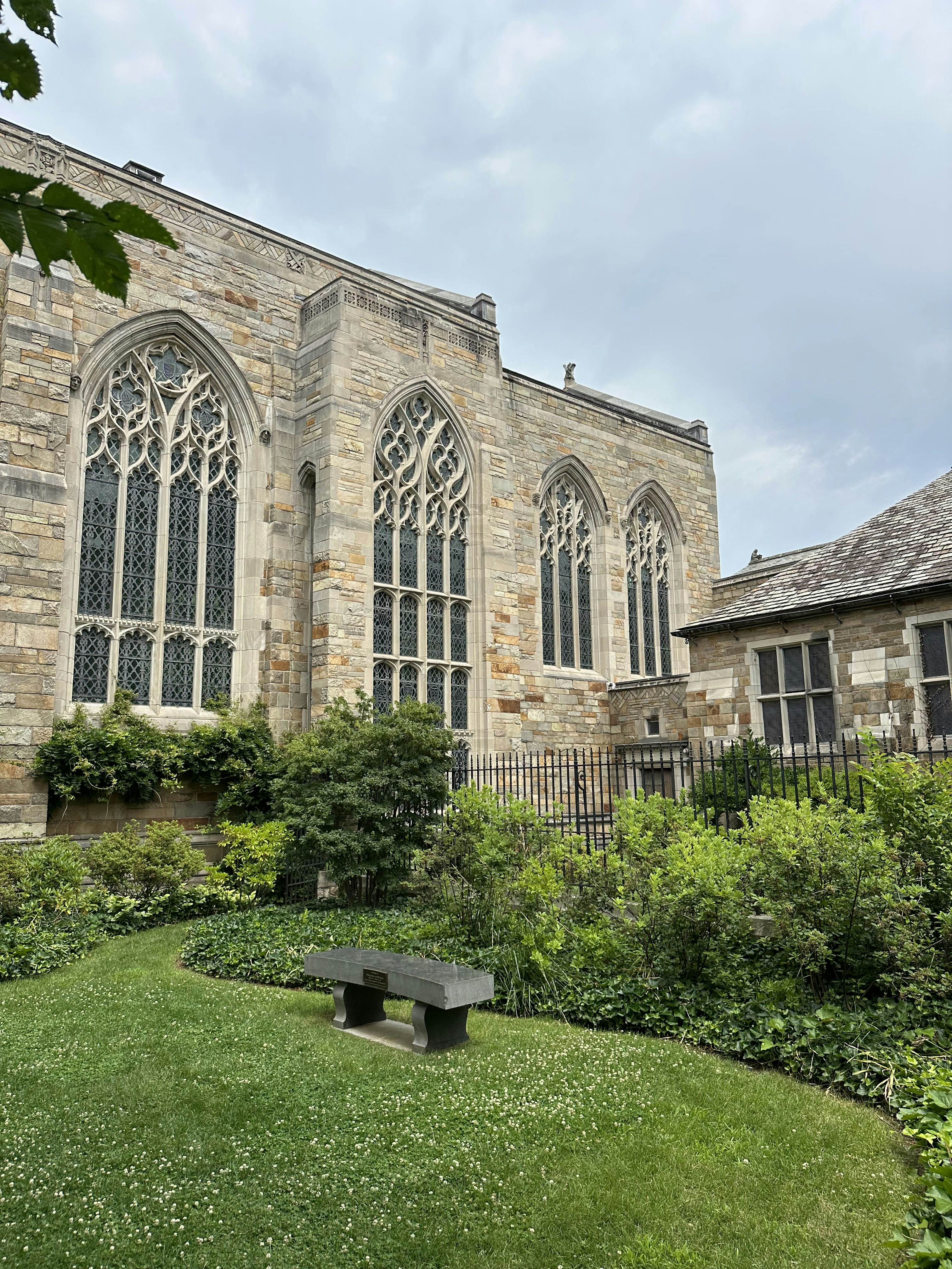 Gothic Grandeur: Sunlit Arches Over a Serene Cloister Garden