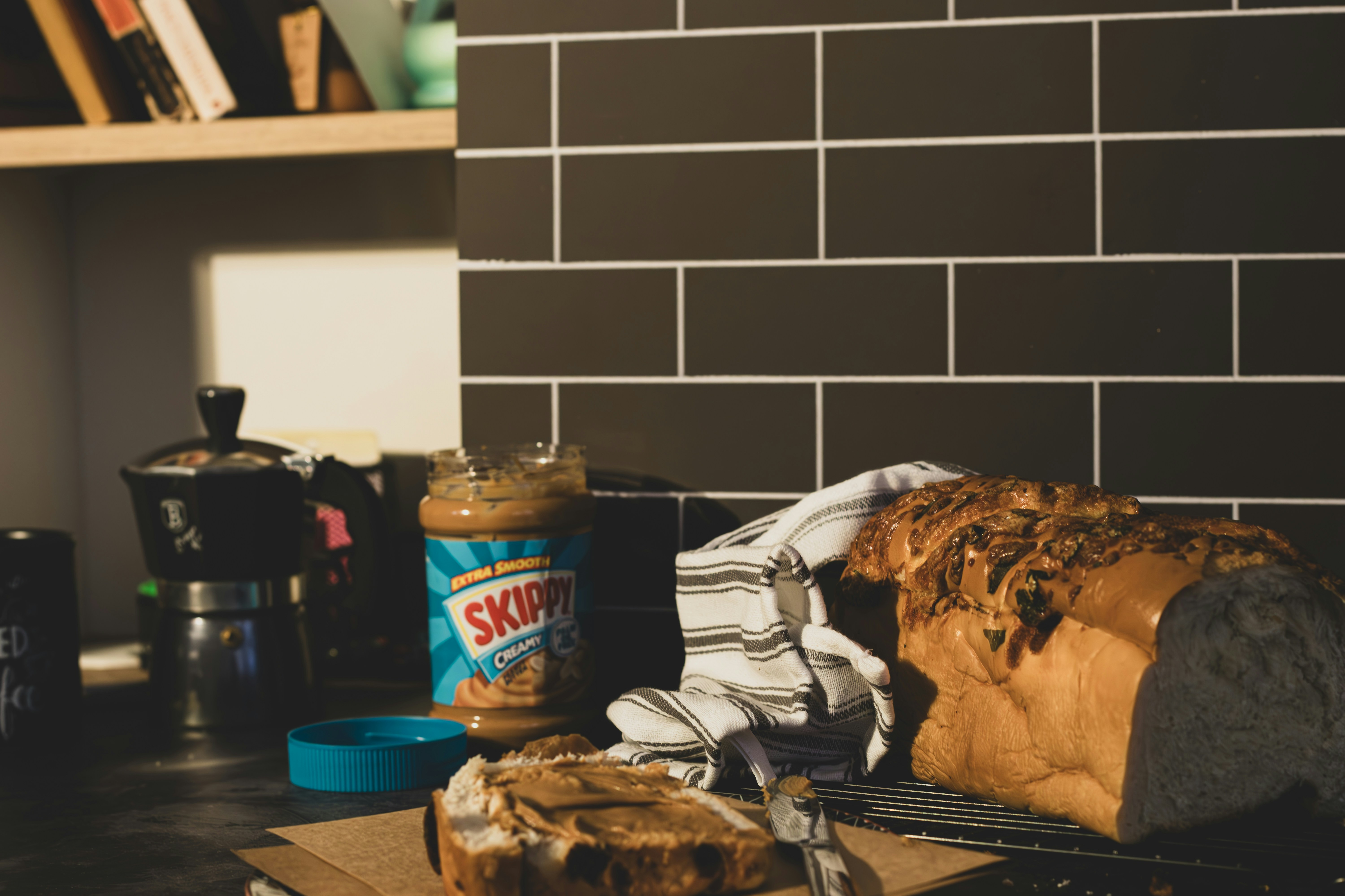 Crumbs and Calm: A rustic loaf cooling beside Skippy in a modern tiled kitchen