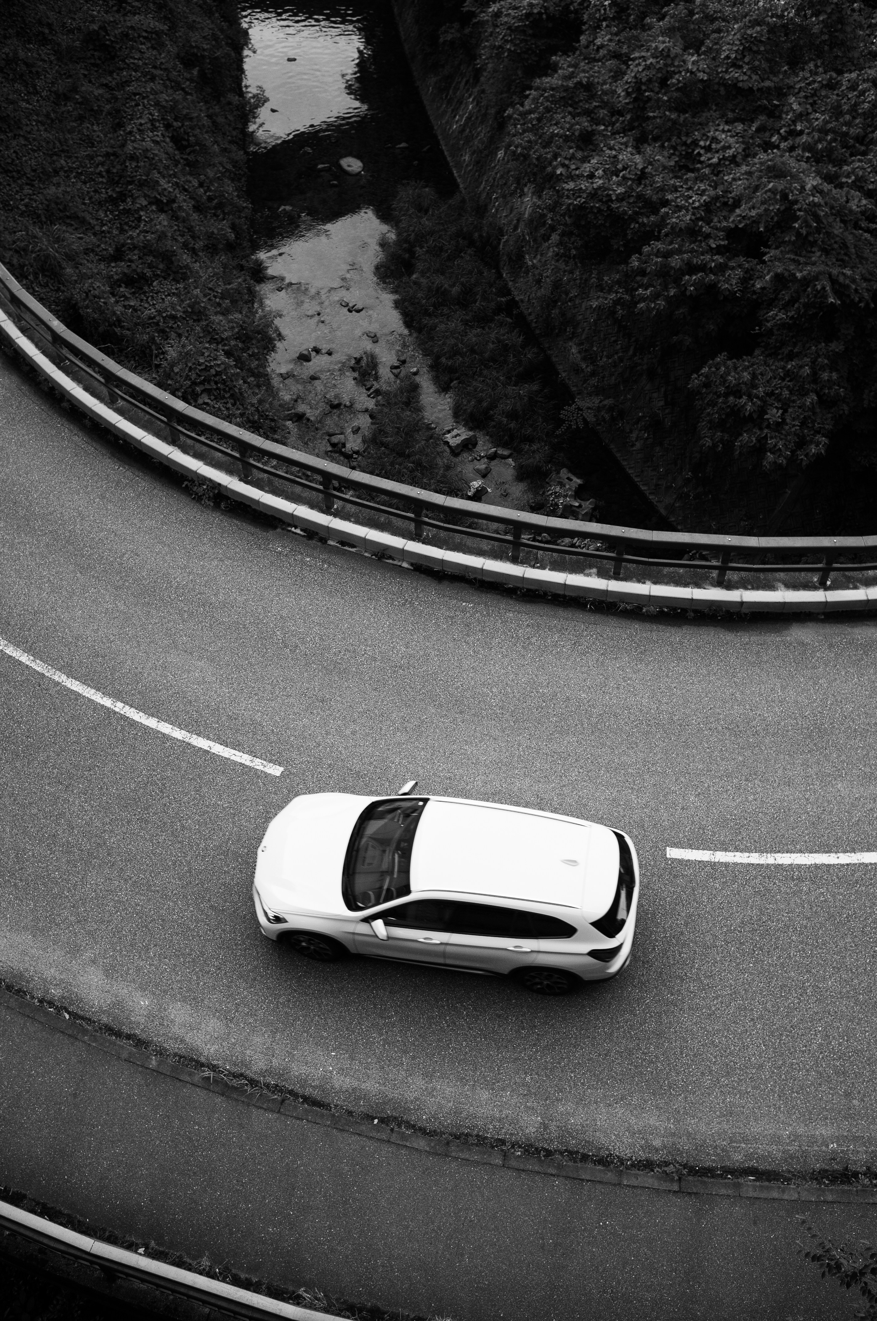 Serpentine Descent: White Sedan Rounds a Hairpin on a Cliffside Road