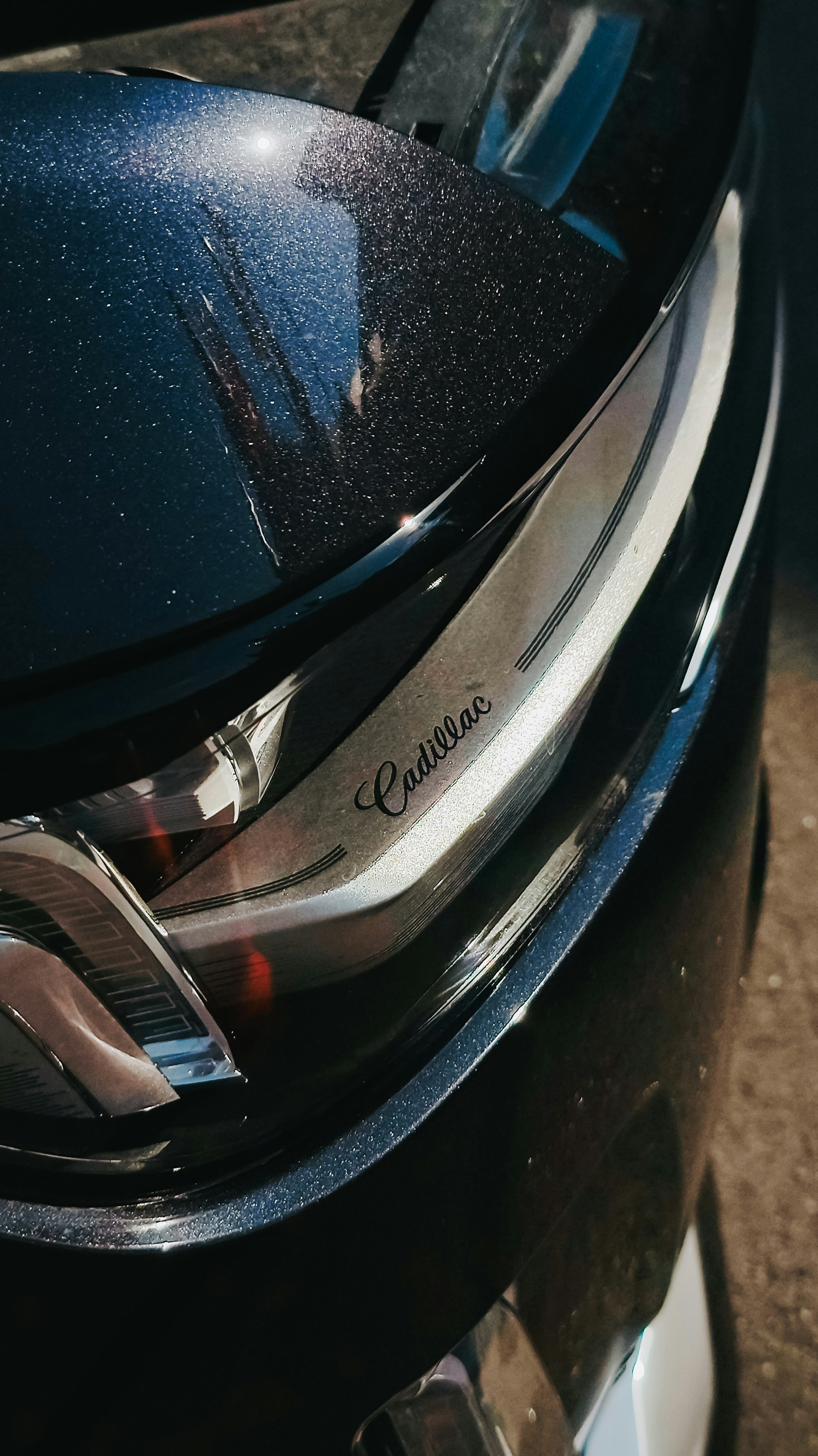 Close-up of a Cadillac emblem and headlight design showcasing intricate details and craftsmanship.