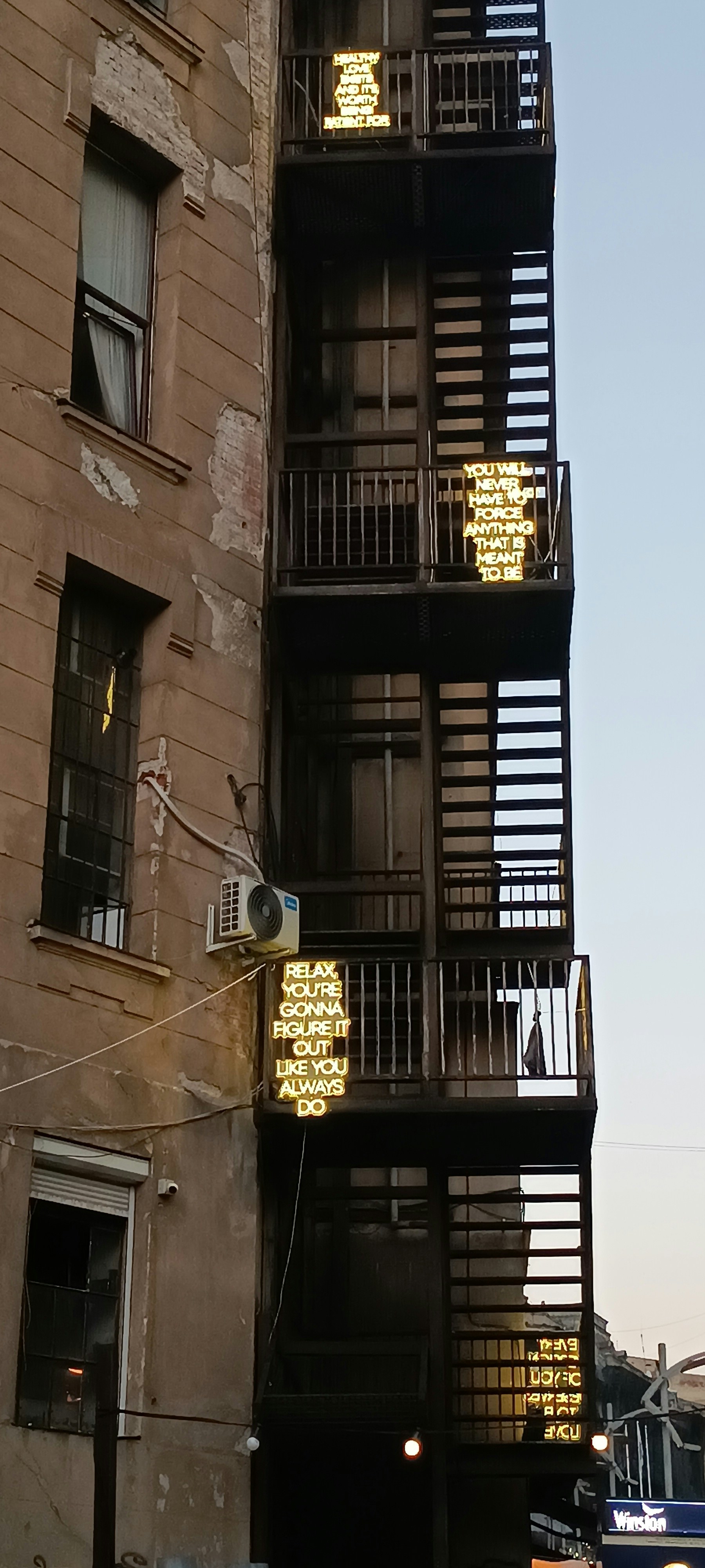 Neon Quotes on a Weathered Fire Escape