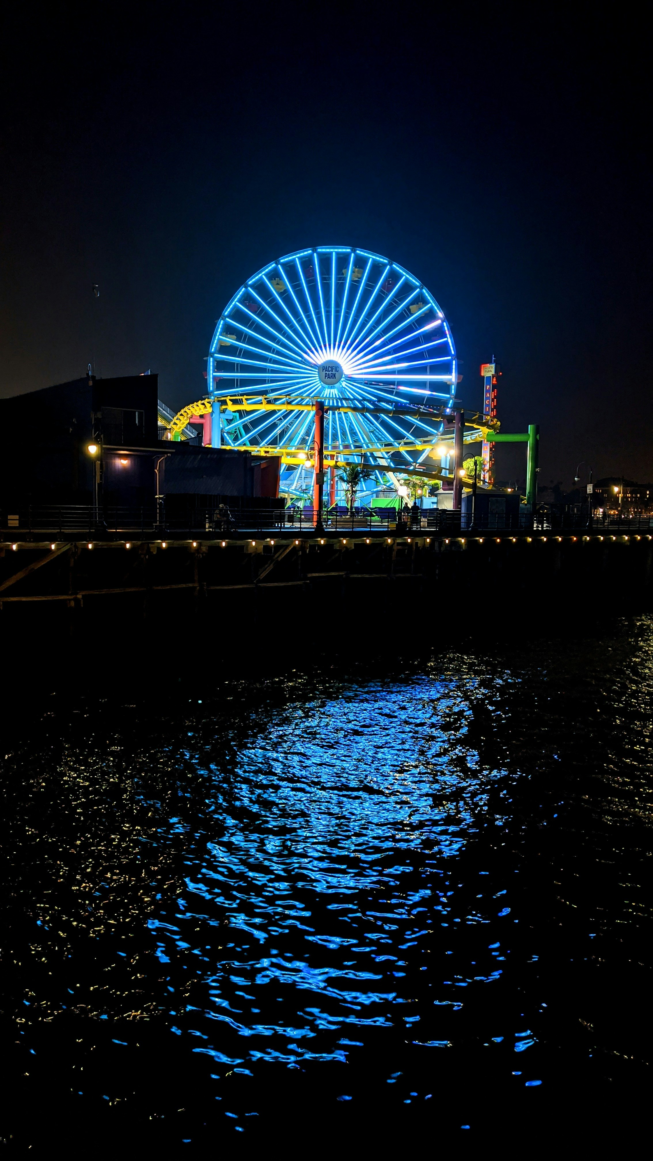 Blue Neon Ferris Wheel Framing the Night Waterfront