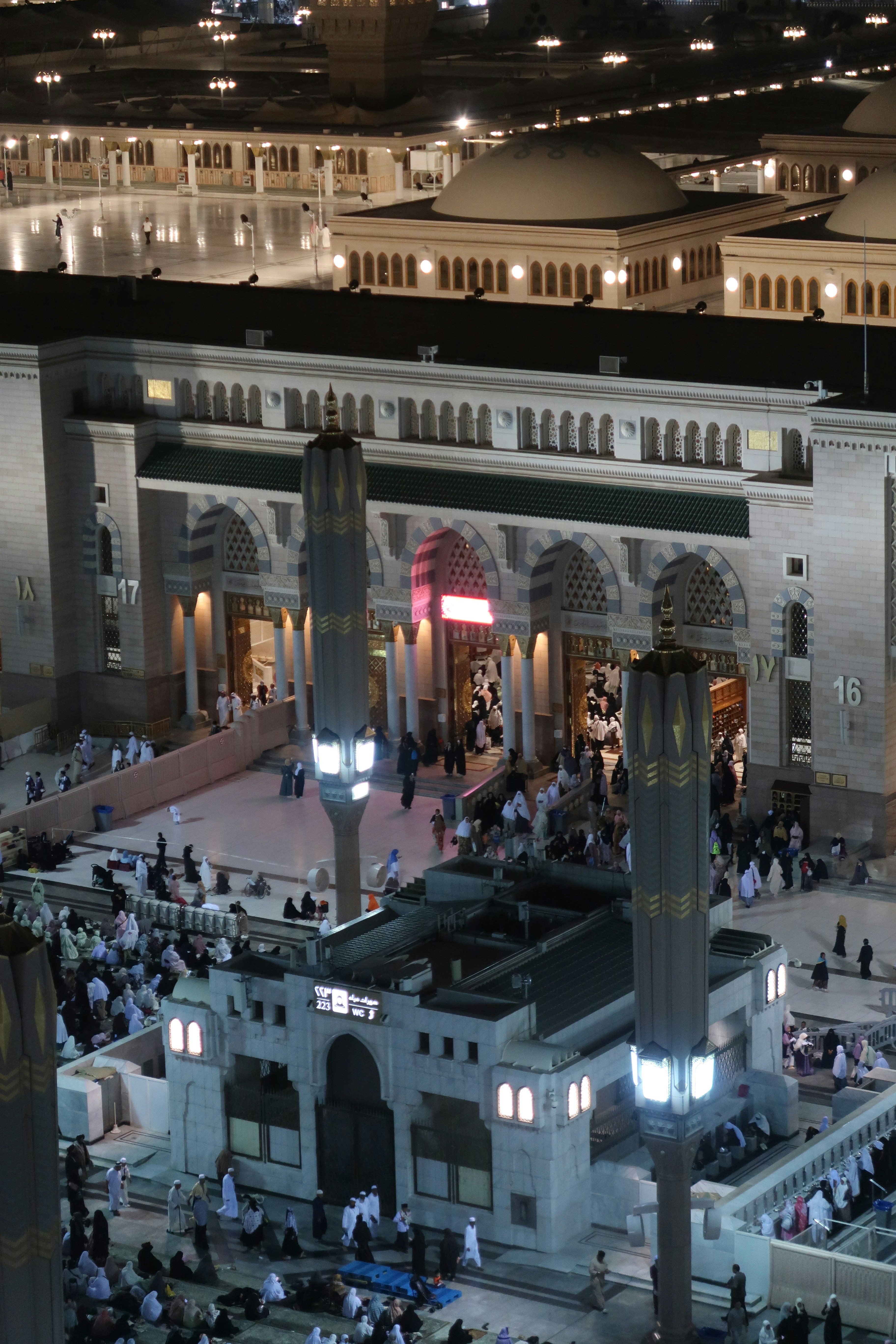 A crowd of people standing around a building at night photo – Free Al ...
