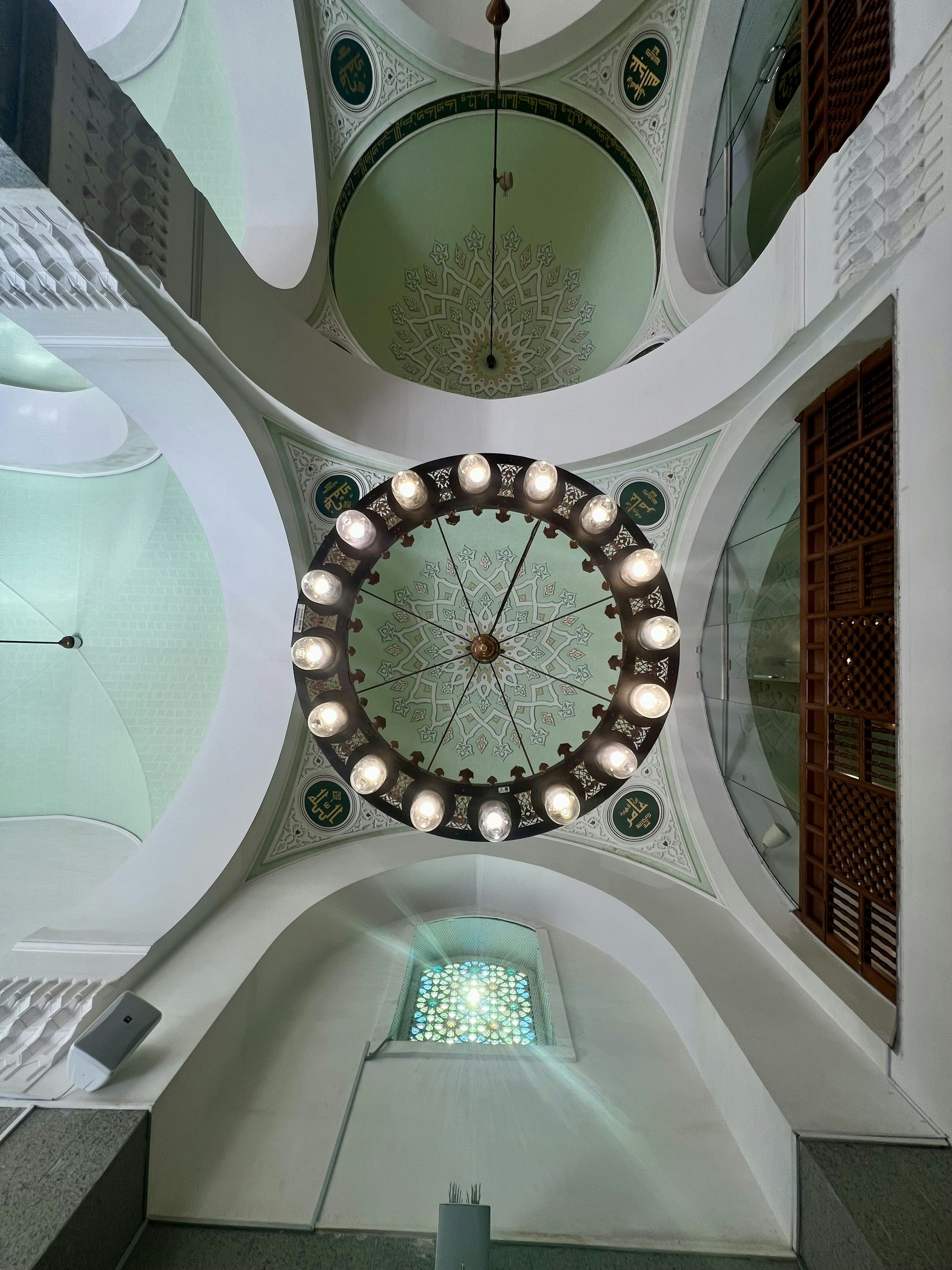 The ceiling of a building with a circular light fixture photo – Free Al ...