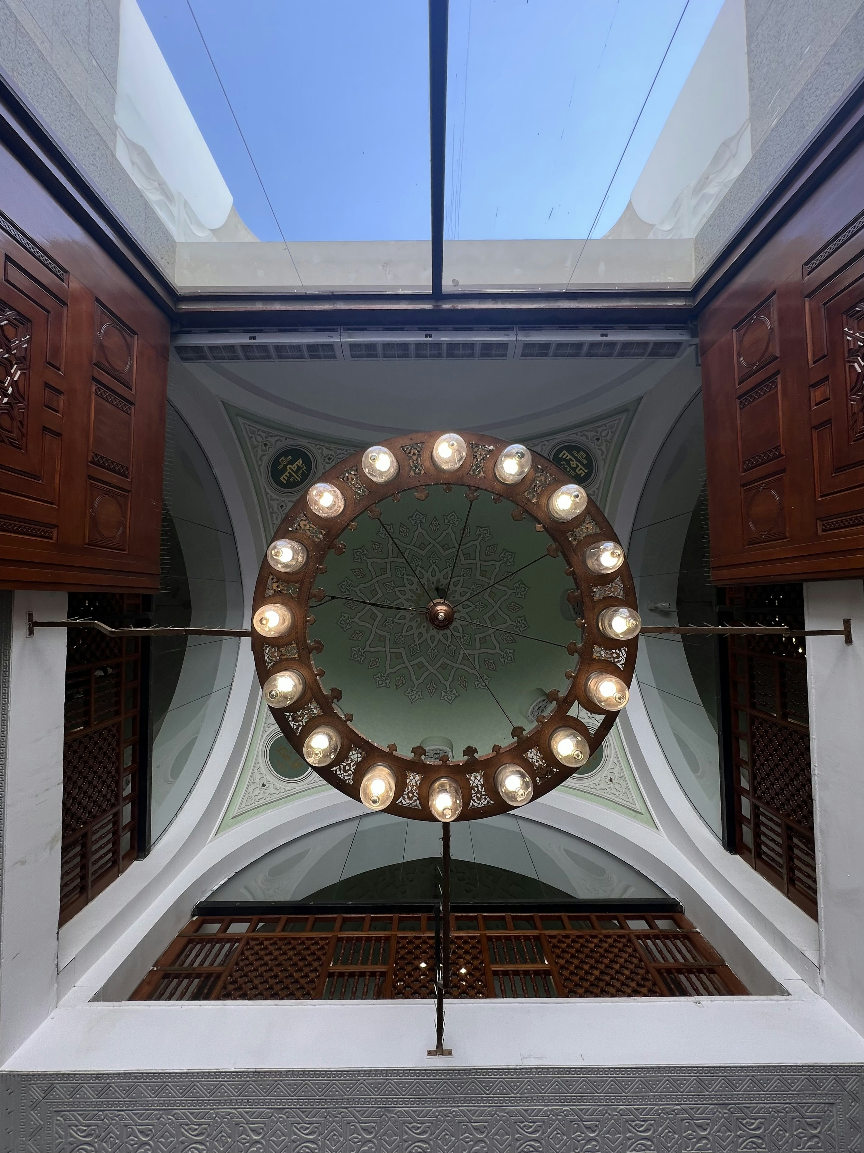 Circular Chandelier Under a Glass Skylight in a Courtyard Atrium