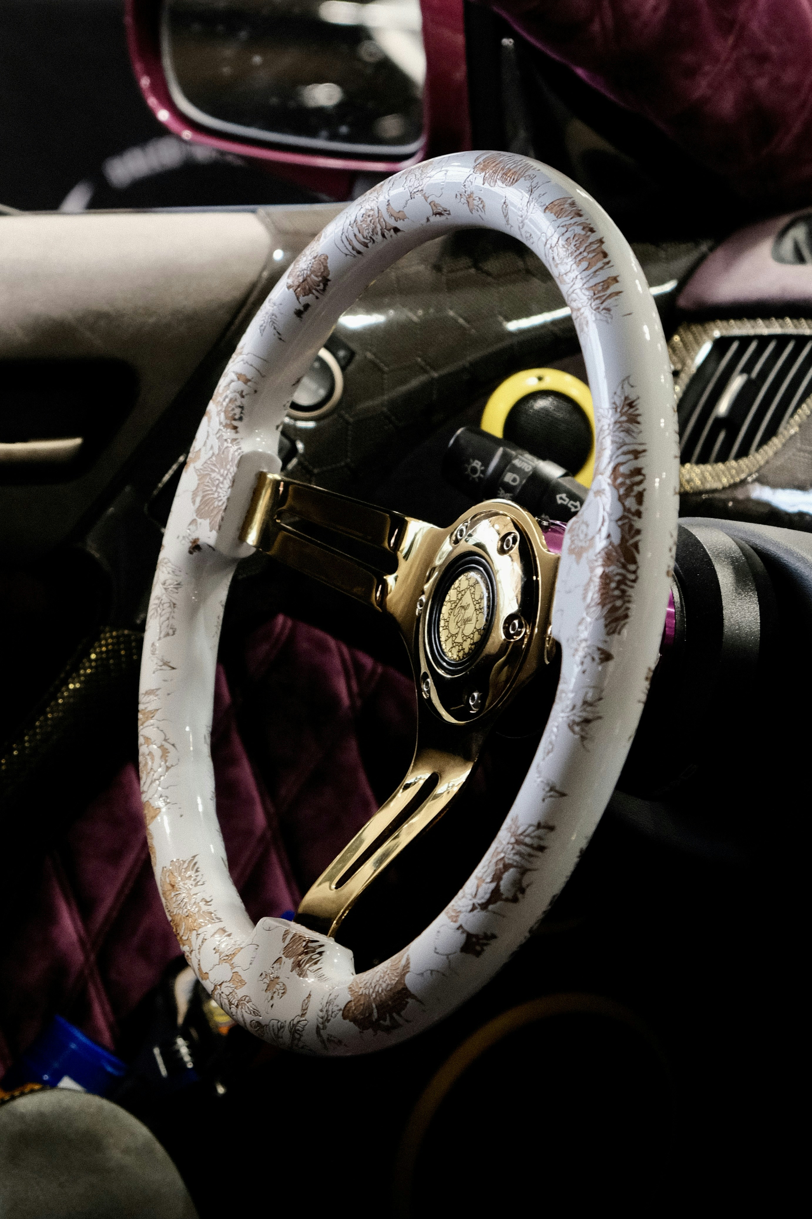Gilded Wheel in a Velvet Cockpit: A Close-Up Portrait of Luxury and Speed