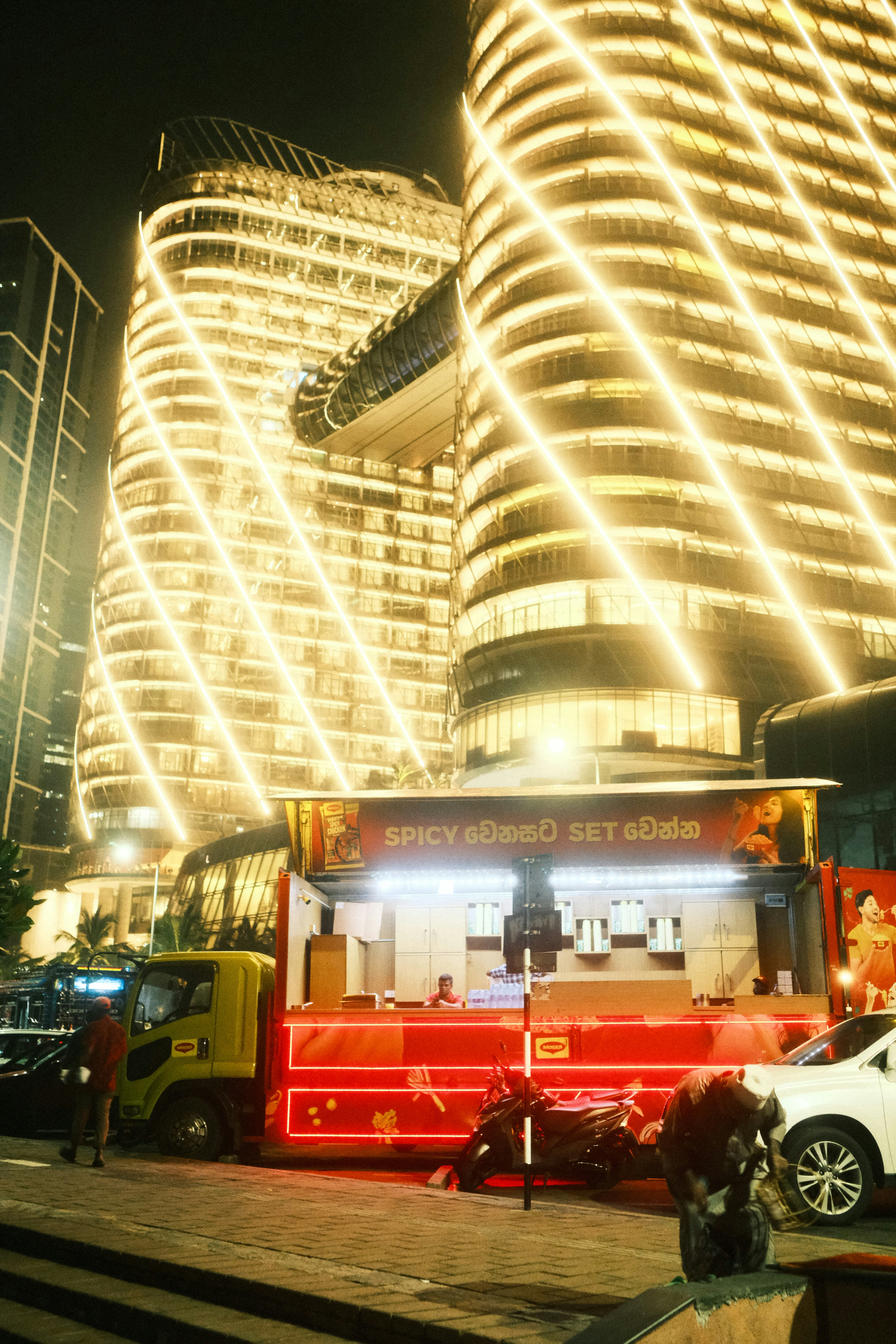 Neon Helixes Over a Night Market: Spiral Towers Framing a Red Street Food Stall