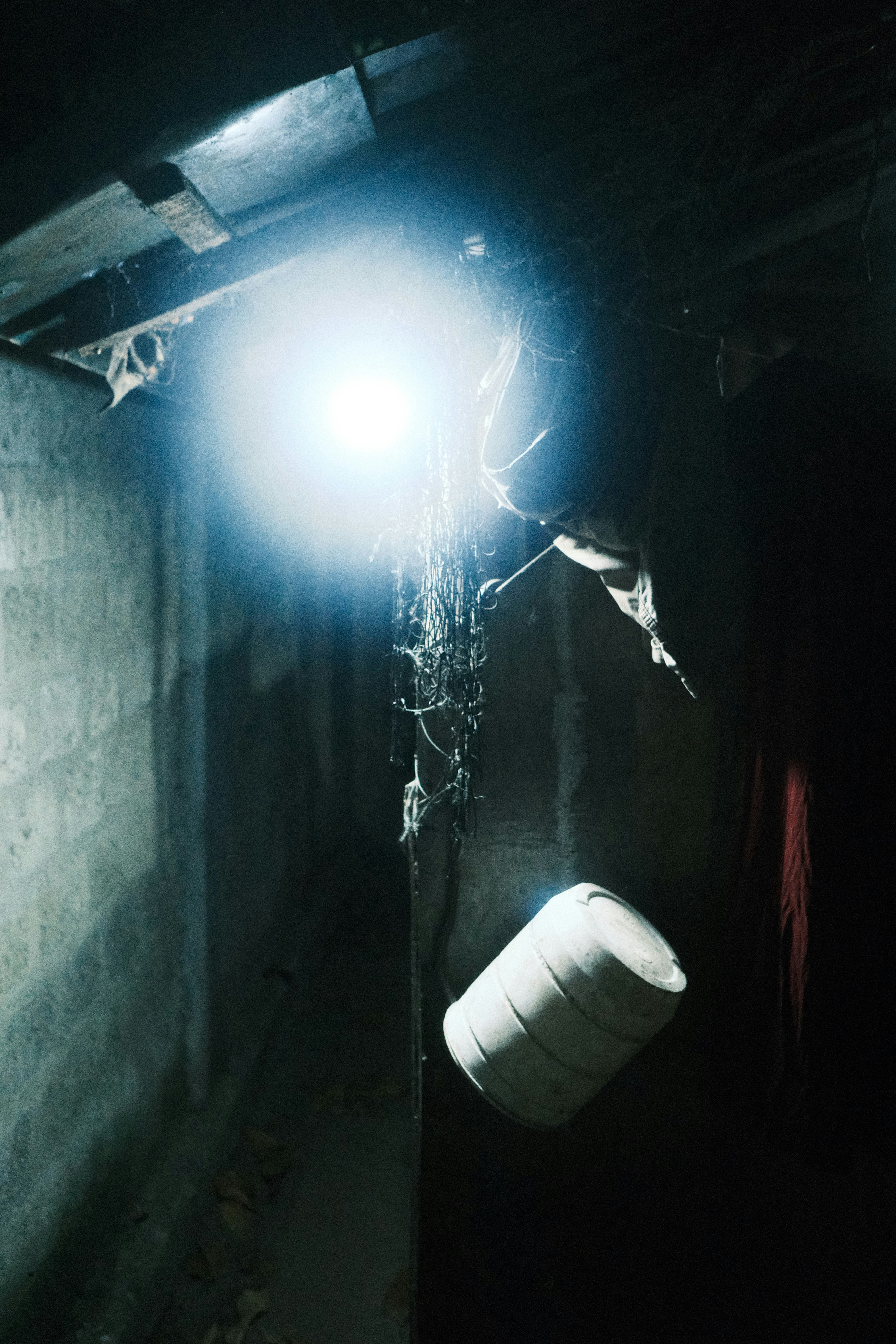 Overhead Beacon Through a Cobwebbed Basement Corridor