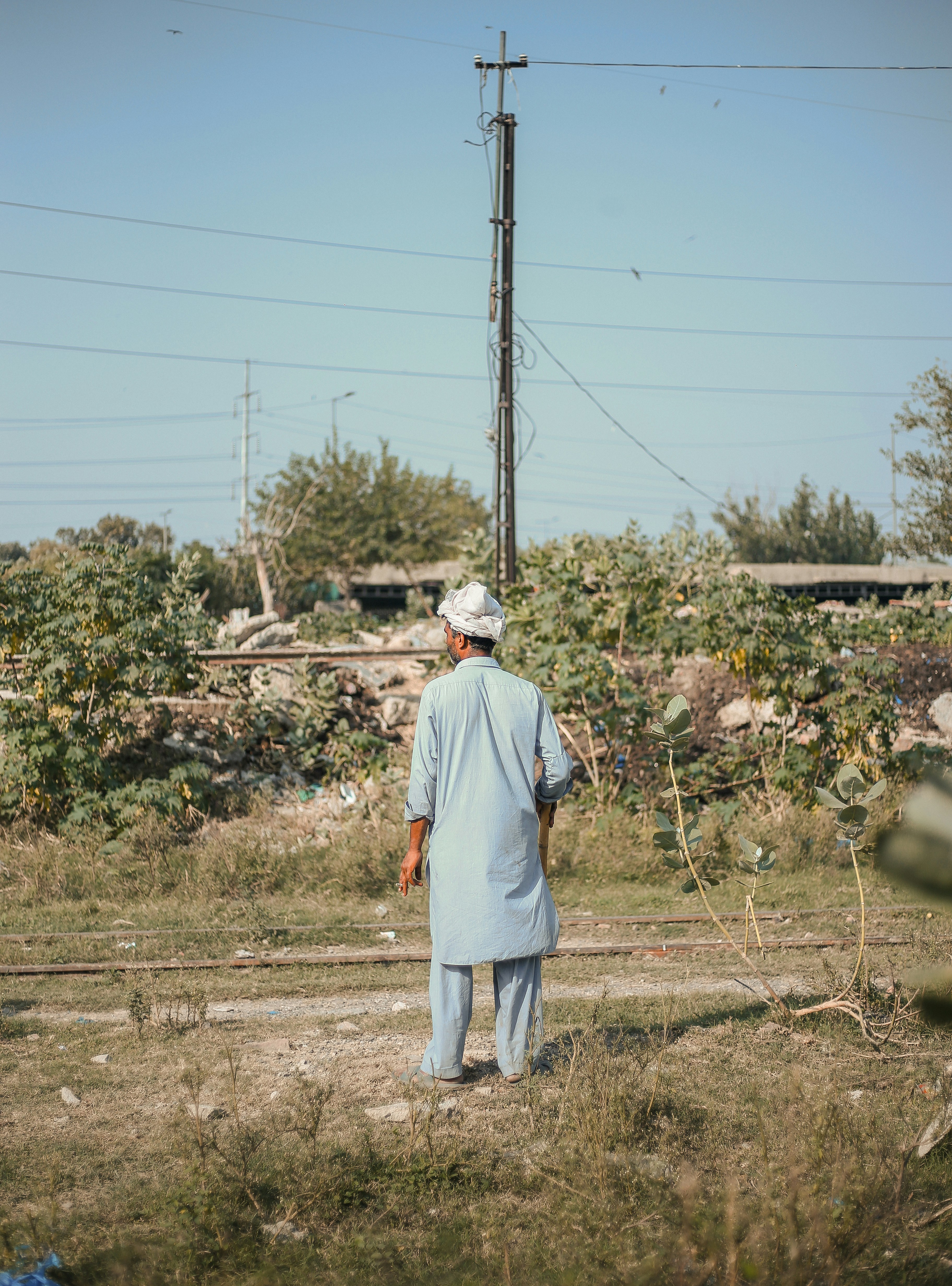 Blue Garb in a Quiet Field: A Solemn Walk Under Power Lines