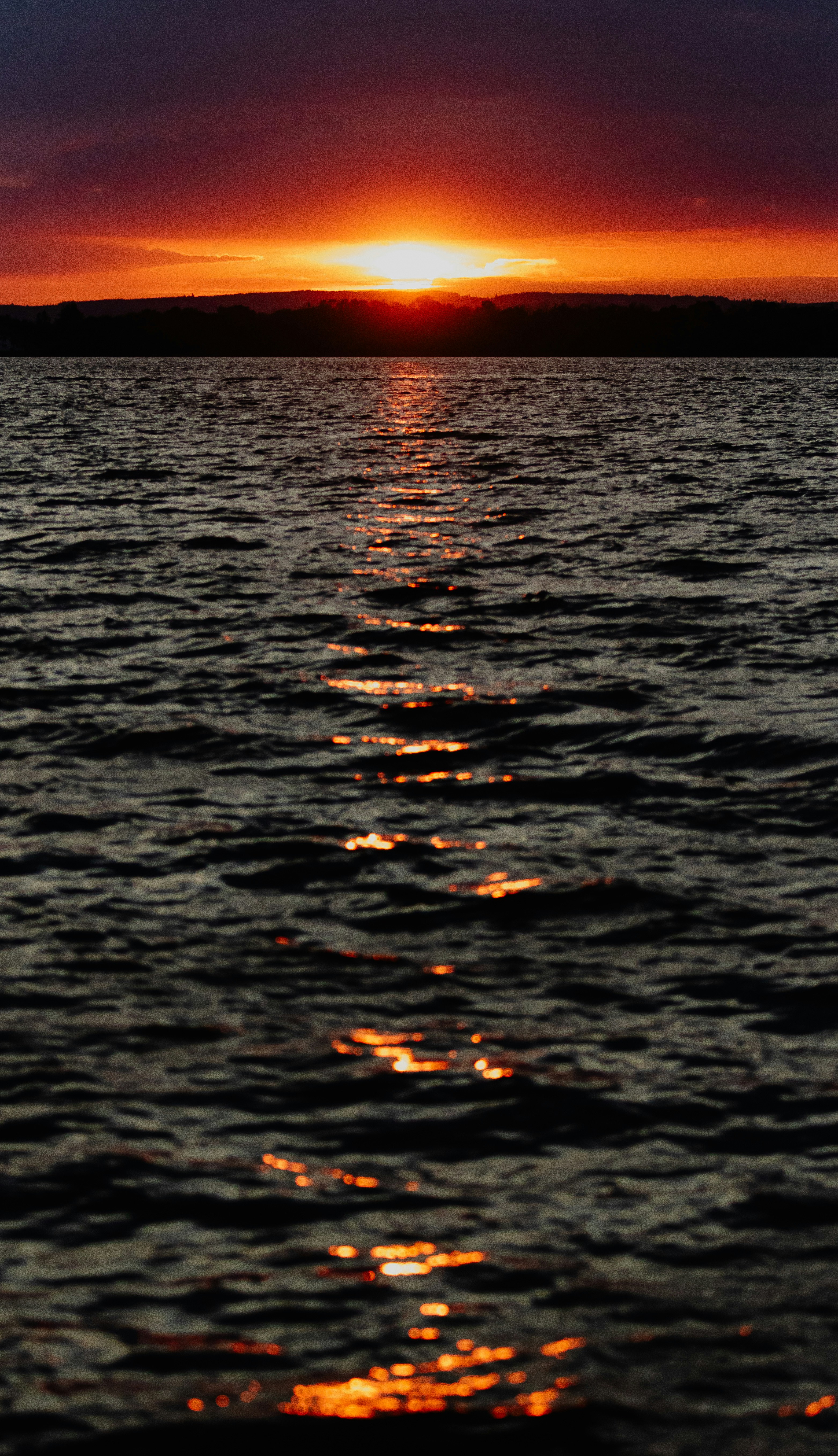 The sun is setting over a body of water photo – Free Sunset Image on ...