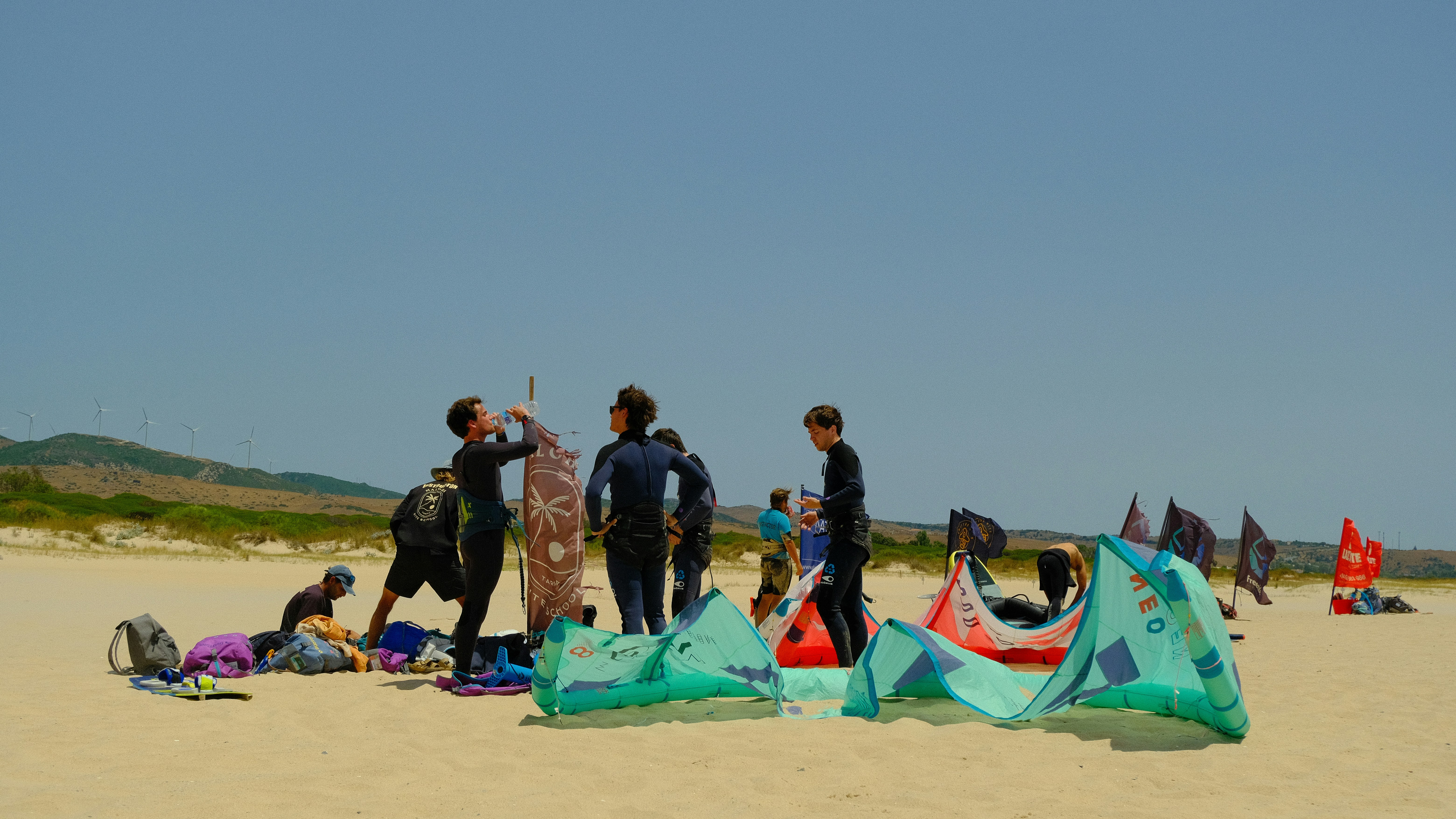 Coastal Kite Crew: Friends Prep and Play on Sunlit Dunes
