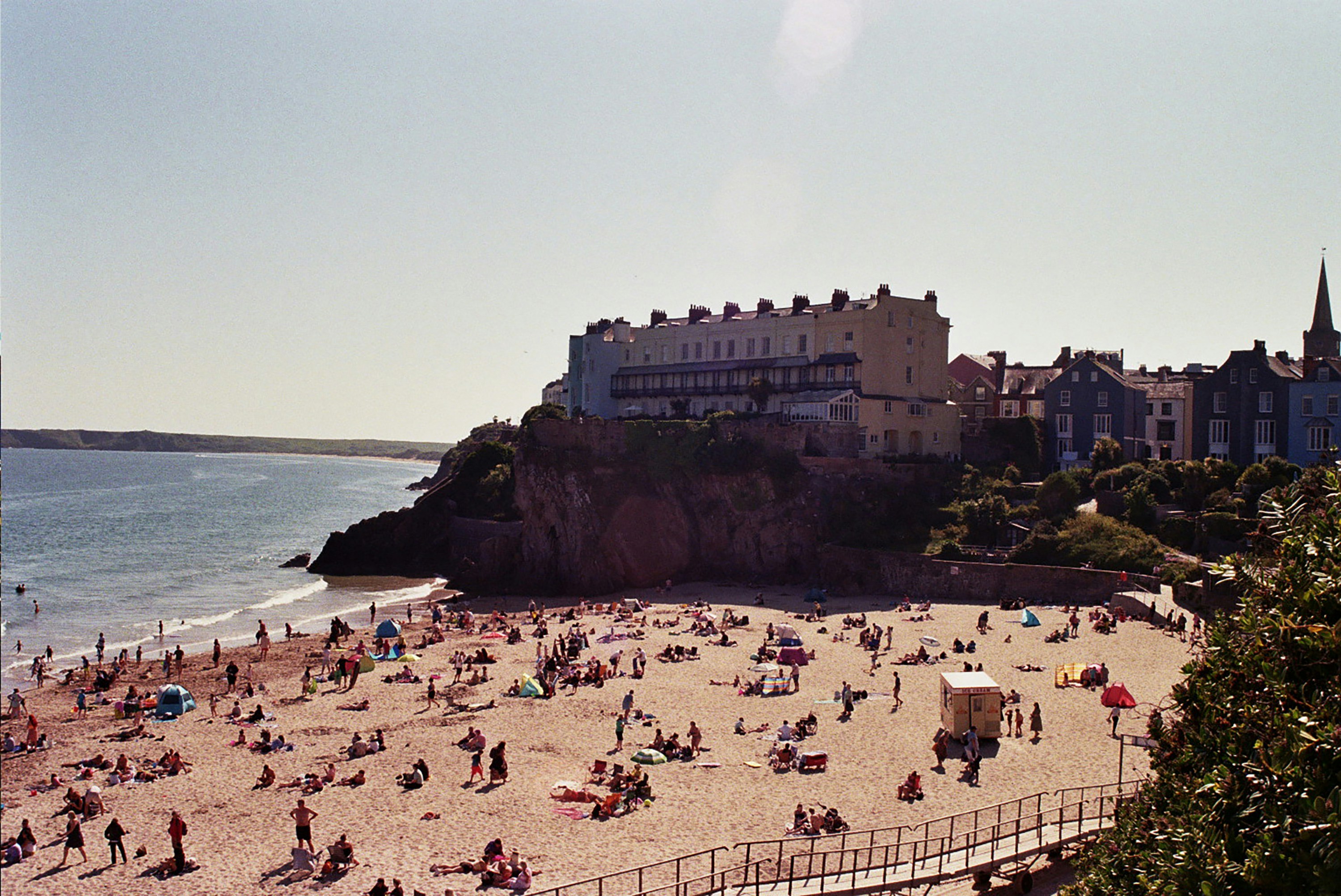 A crowded beach with a castle in the background photo – Free Tenby ...