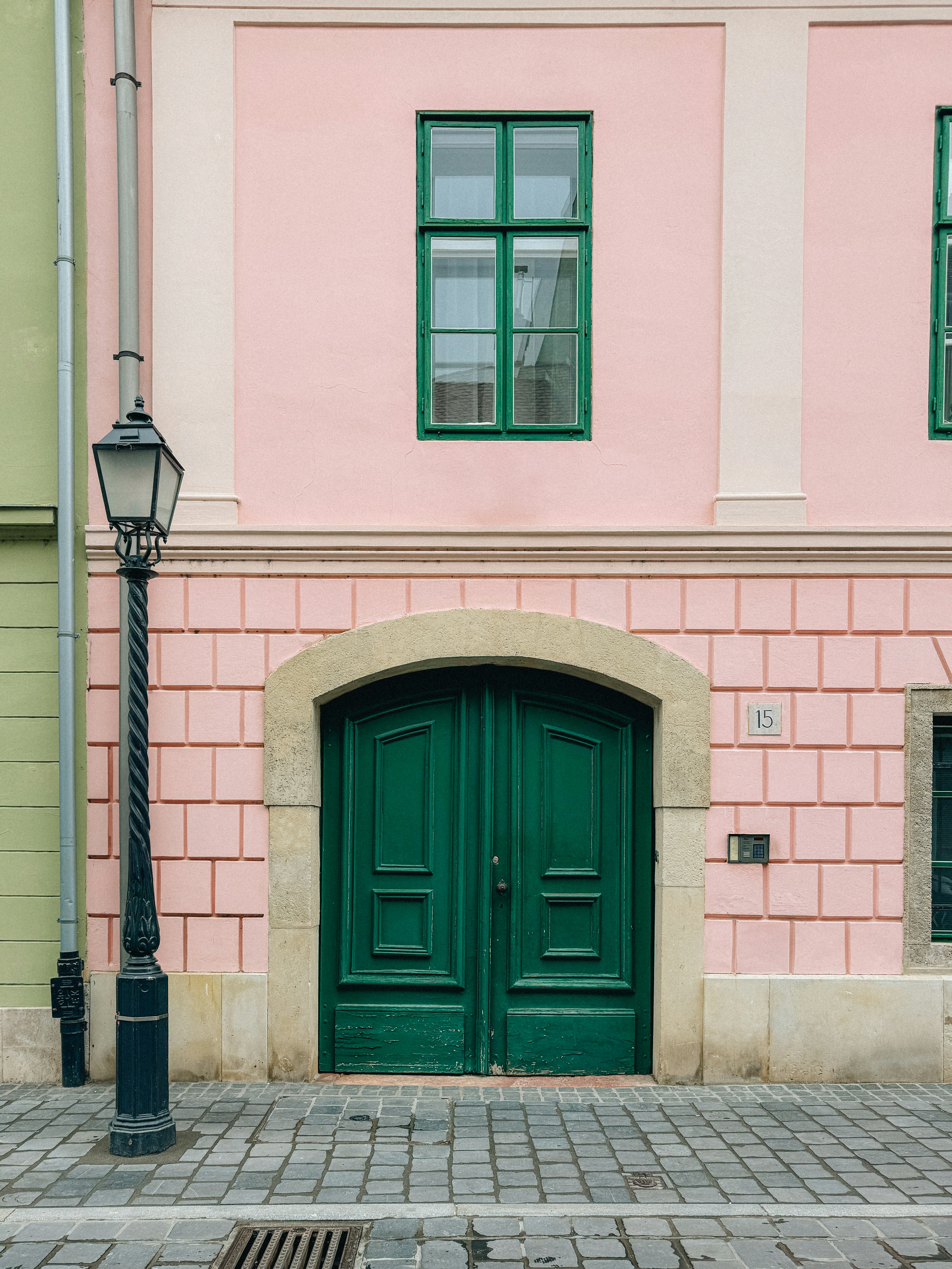 A pink and green building with a green door photo – Free Budapest Image ...
