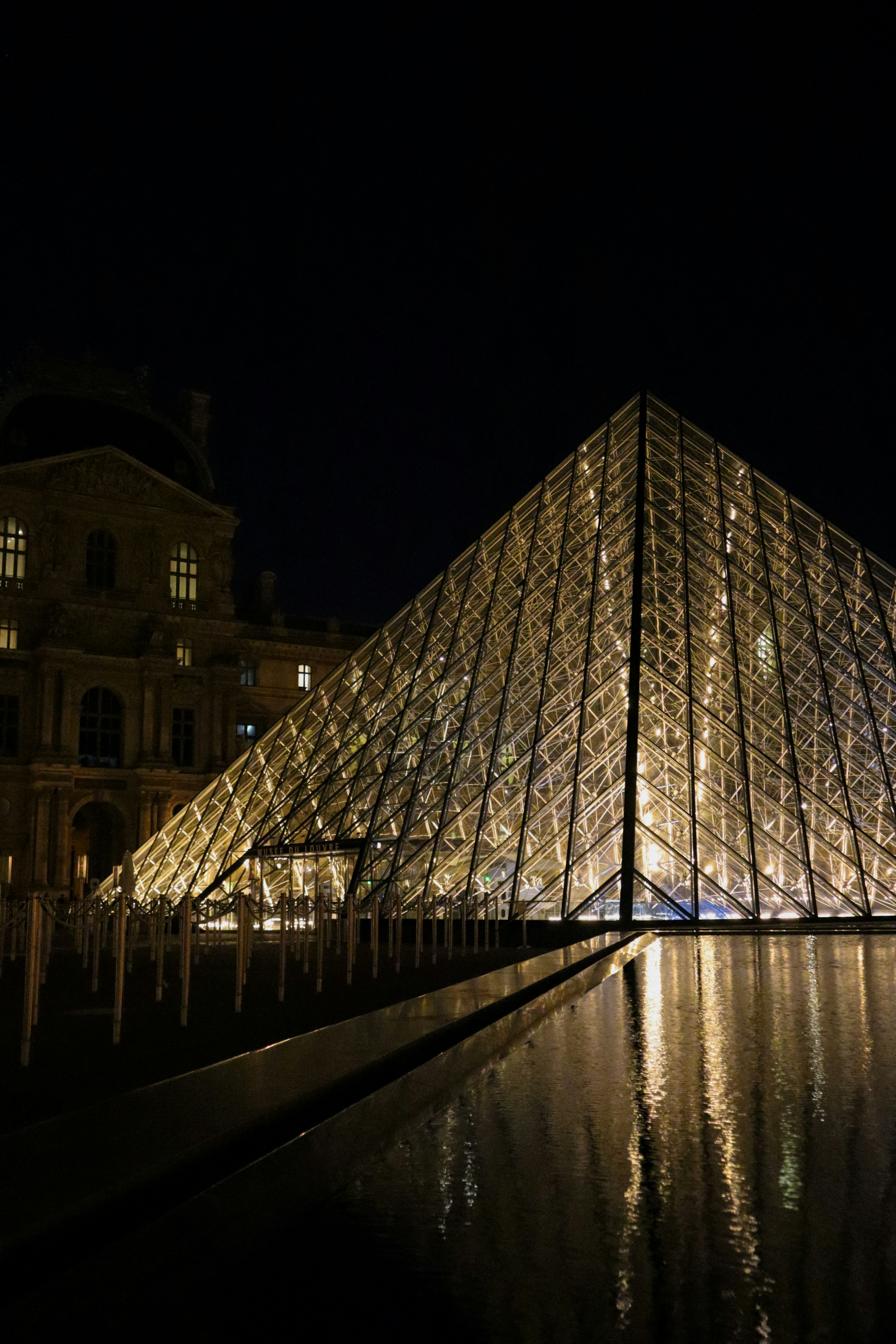 A large glass pyramid sitting in the middle of a body of water photo ...