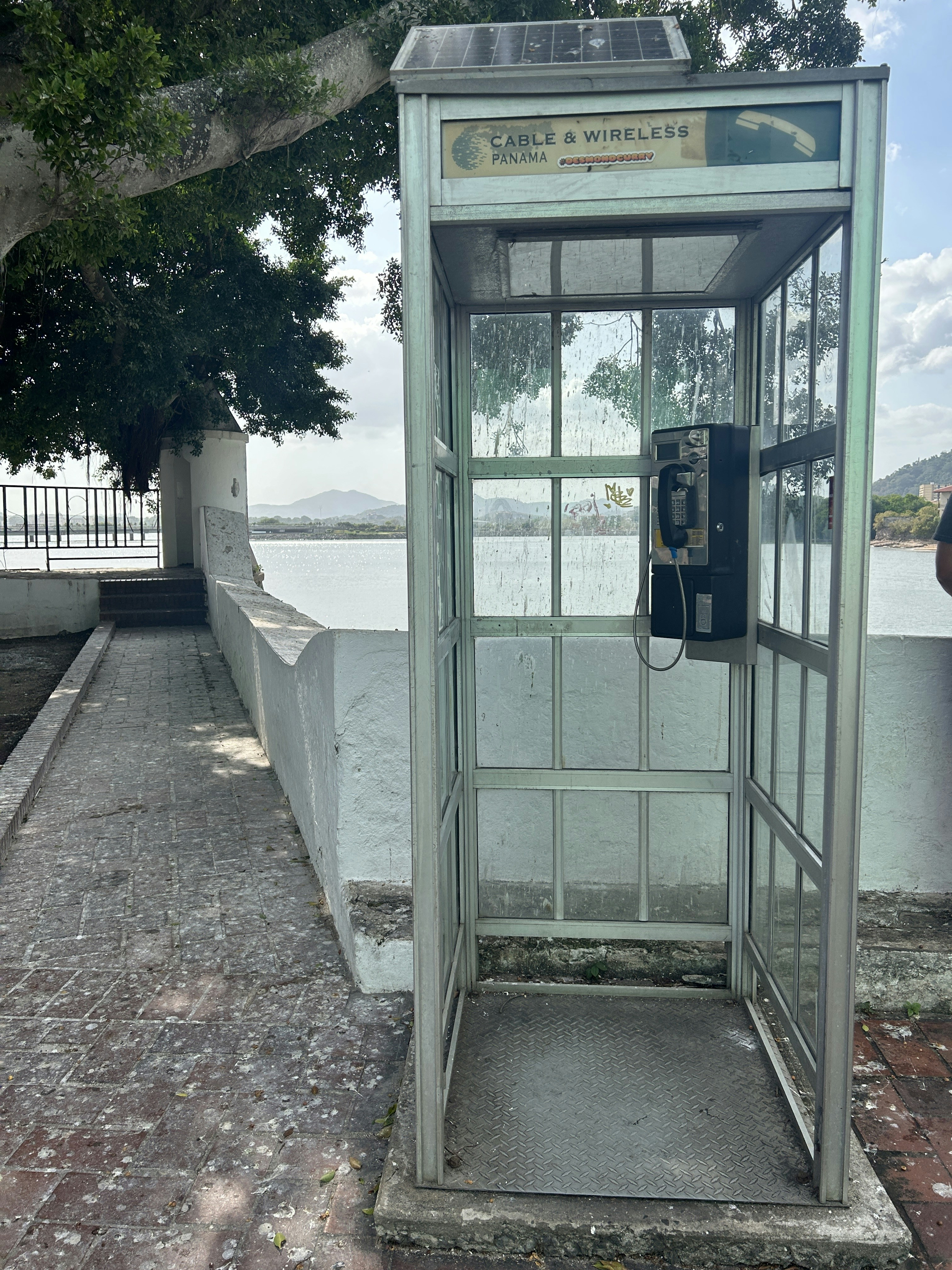 A public phone booth sitting on the side of a road photo – Free Phone ...