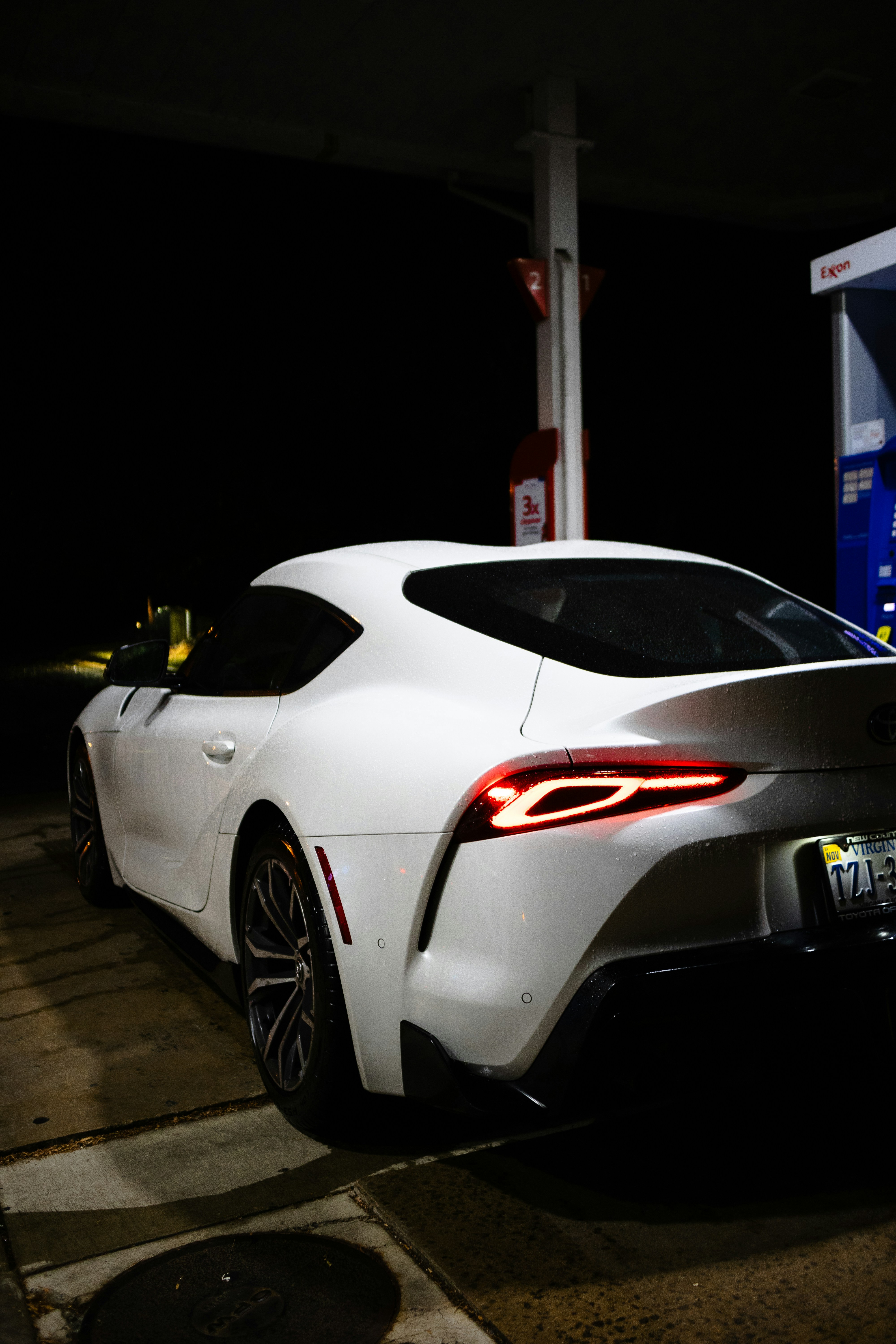 Neon Tail Lights and White Curves: Midnight Stop at a Gas Station