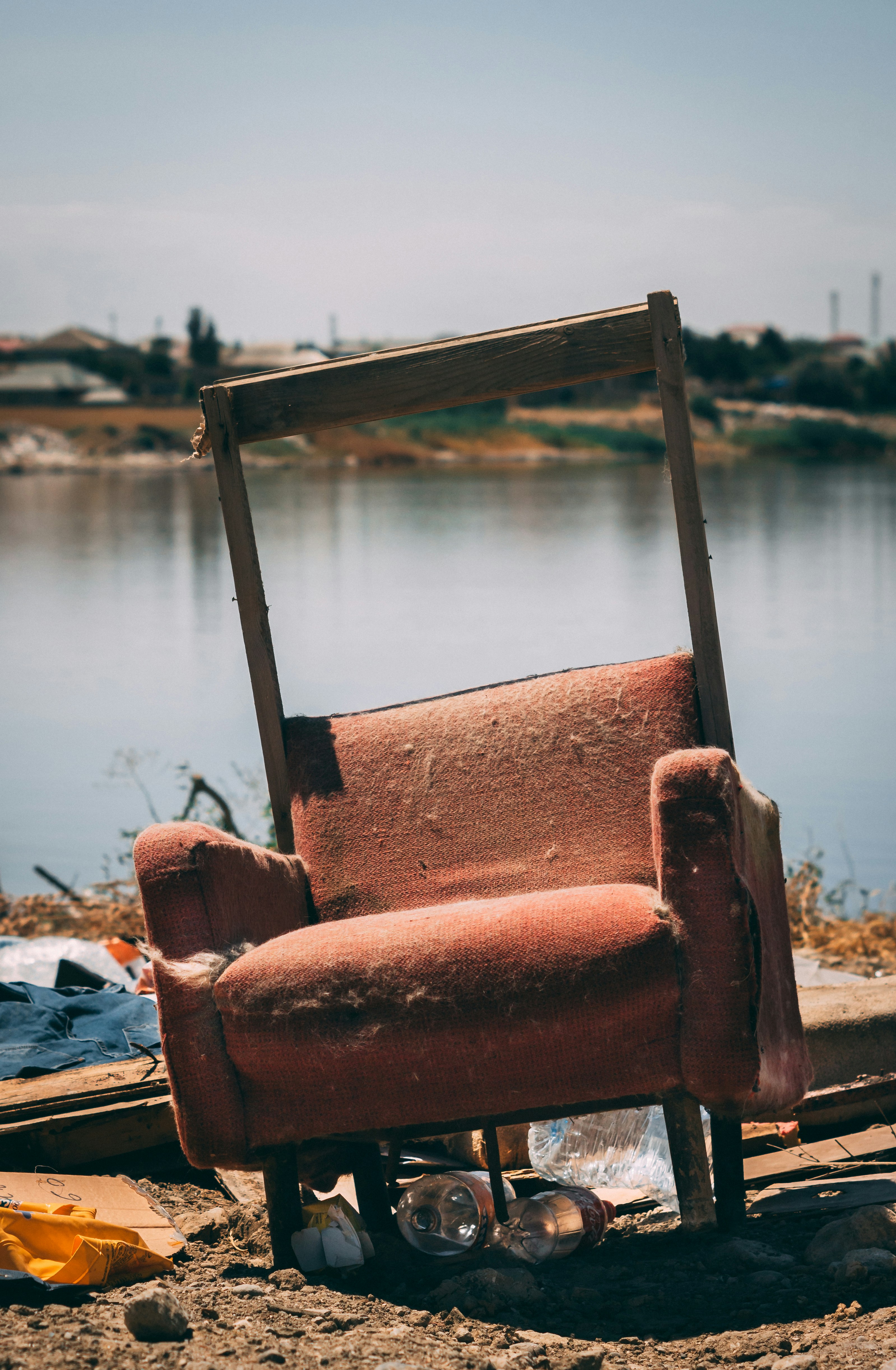 Red Armchair Adrift by a Quiet Riverside
