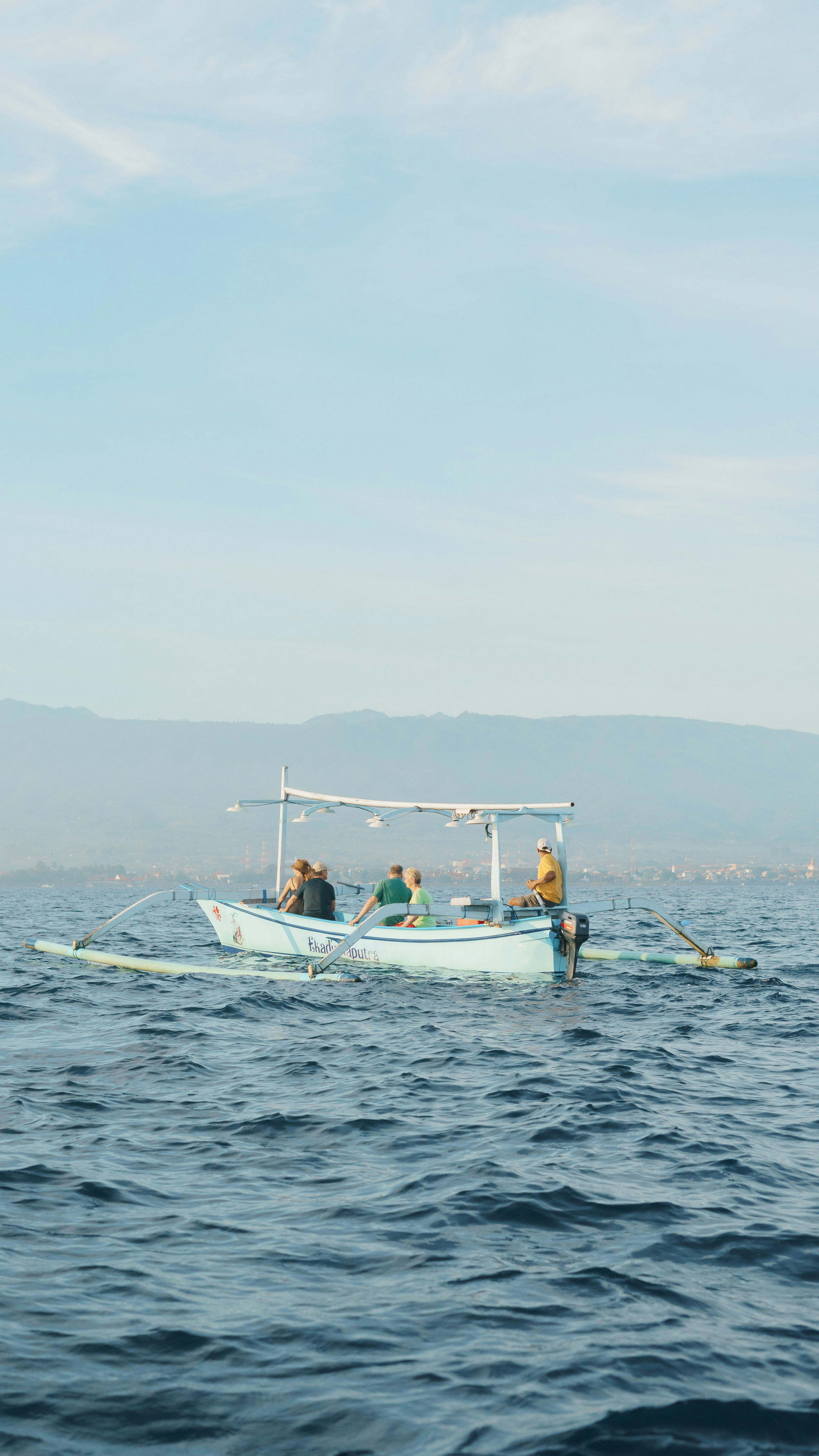 Blue Vessel on a Quiet Sea: A Small Crew Beneath a Pale Sky