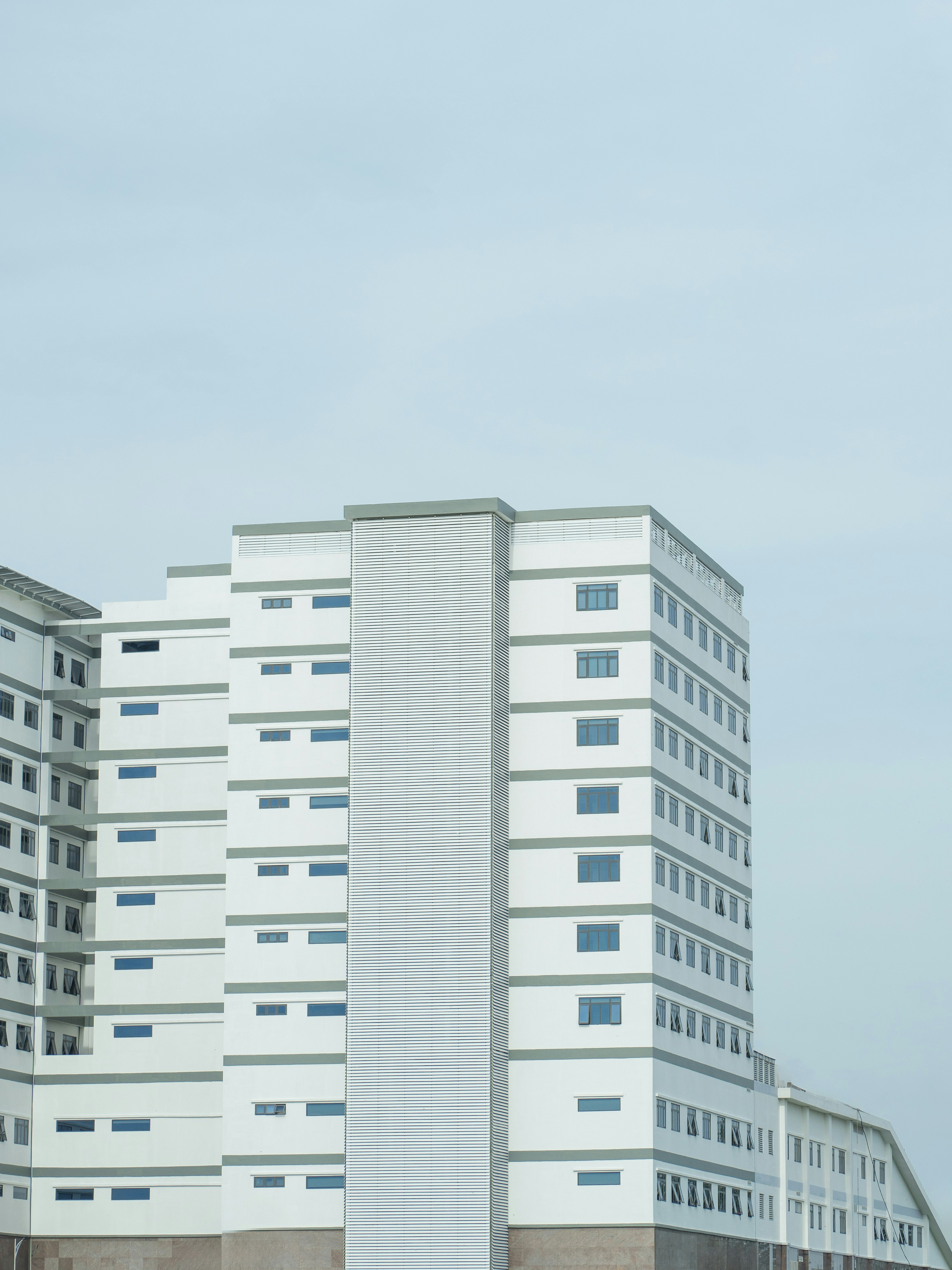 Contemporary building facade showcasing geometric patterns and clean lines under a soft sky.