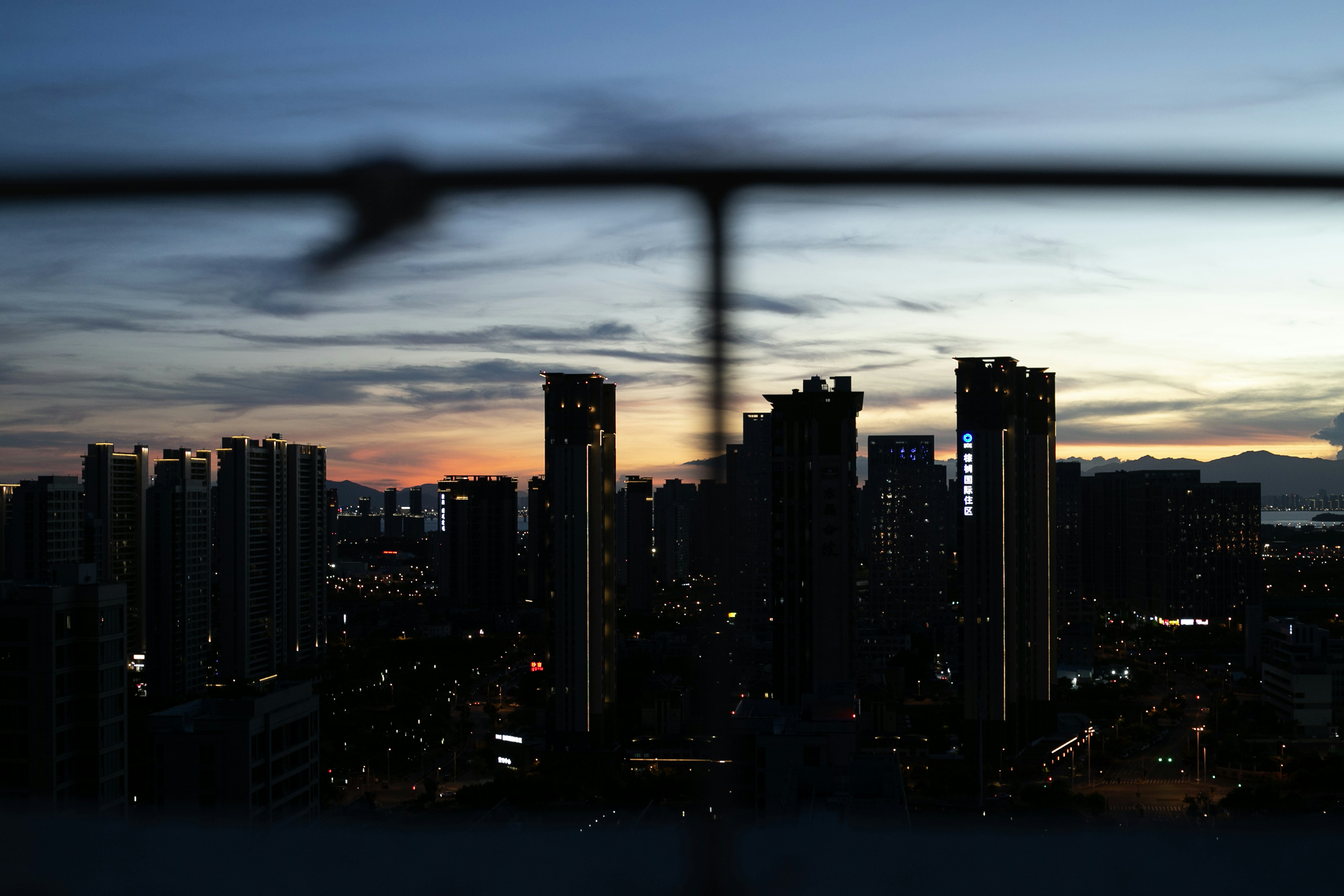 Dusk Over the City: Skyline through a Narrow Foreground Rail