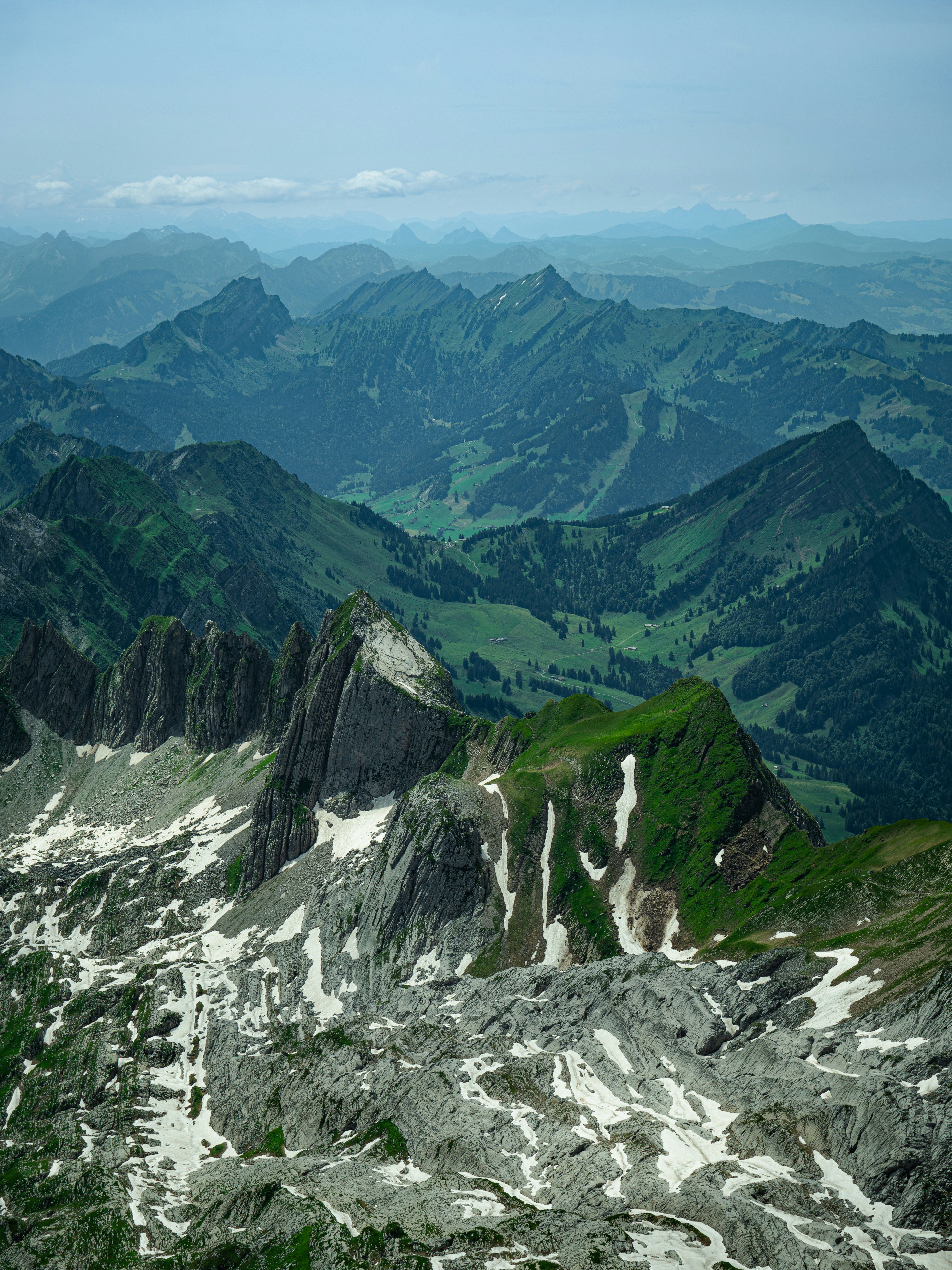 Snow-Scarred Ridge Over Verdant Alpine Valleys