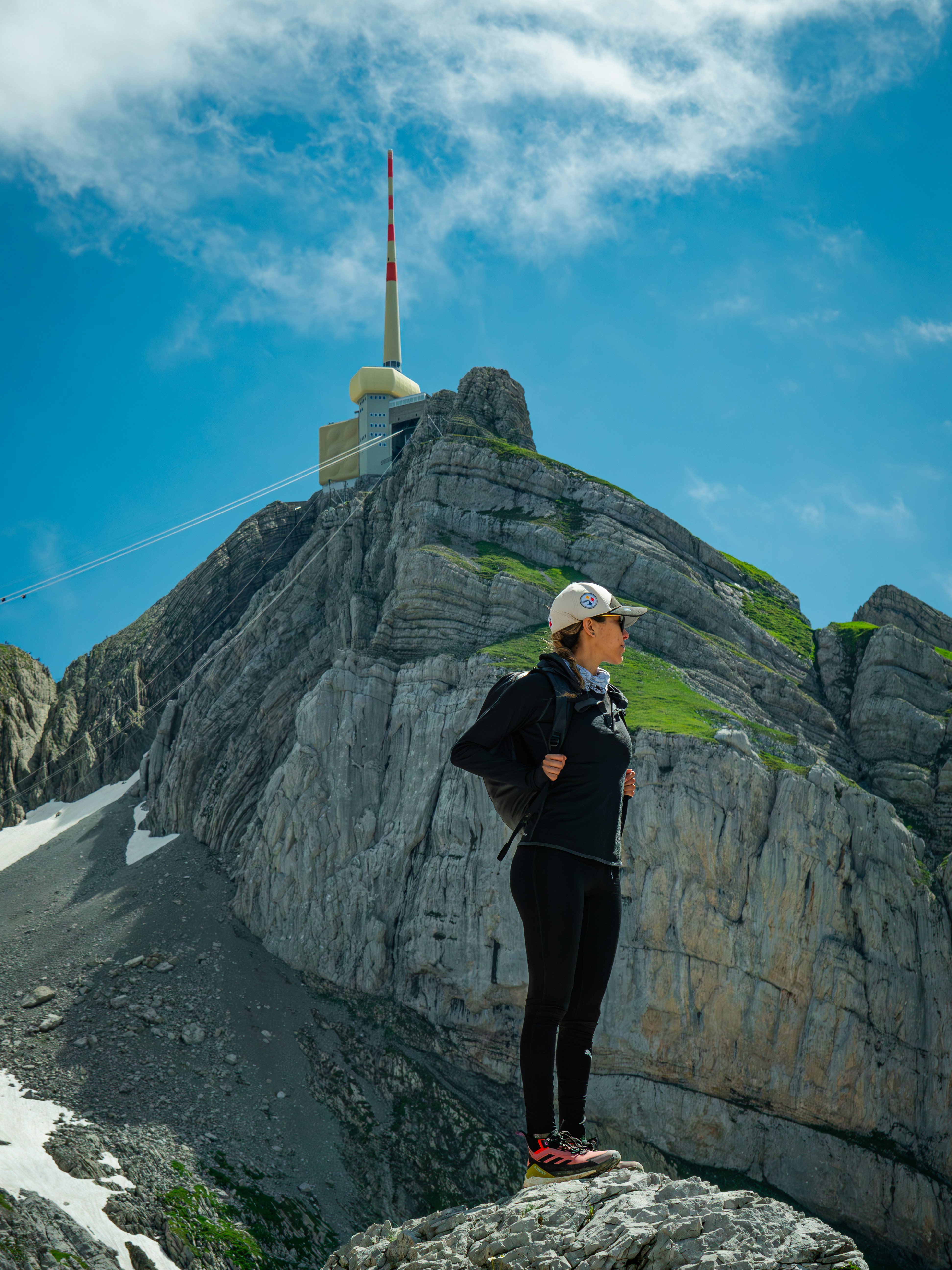Climber on a granite ridge beneath a summit antenna