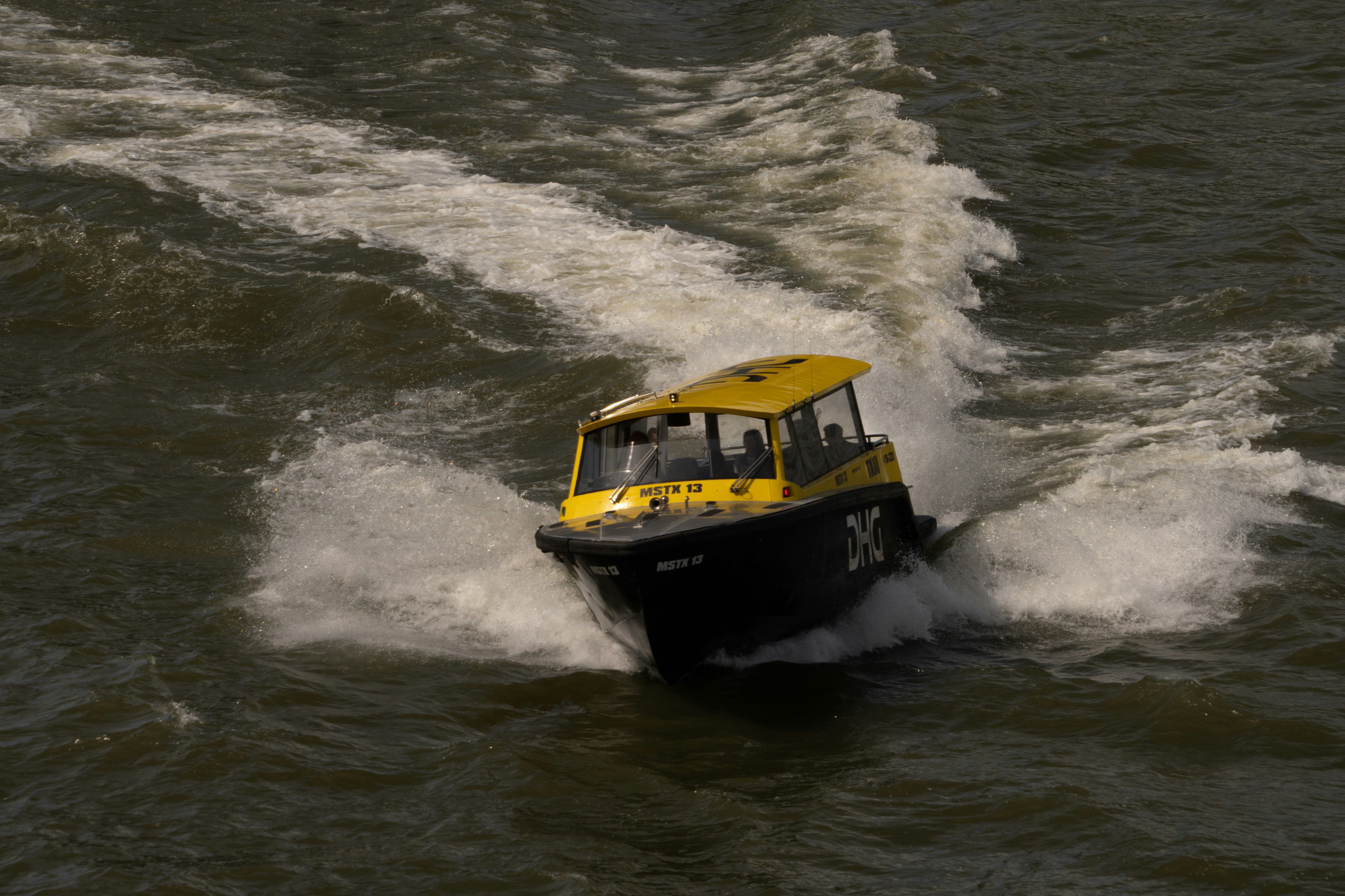 Yellow Utility Boat Rips Through Choppy River Currents
