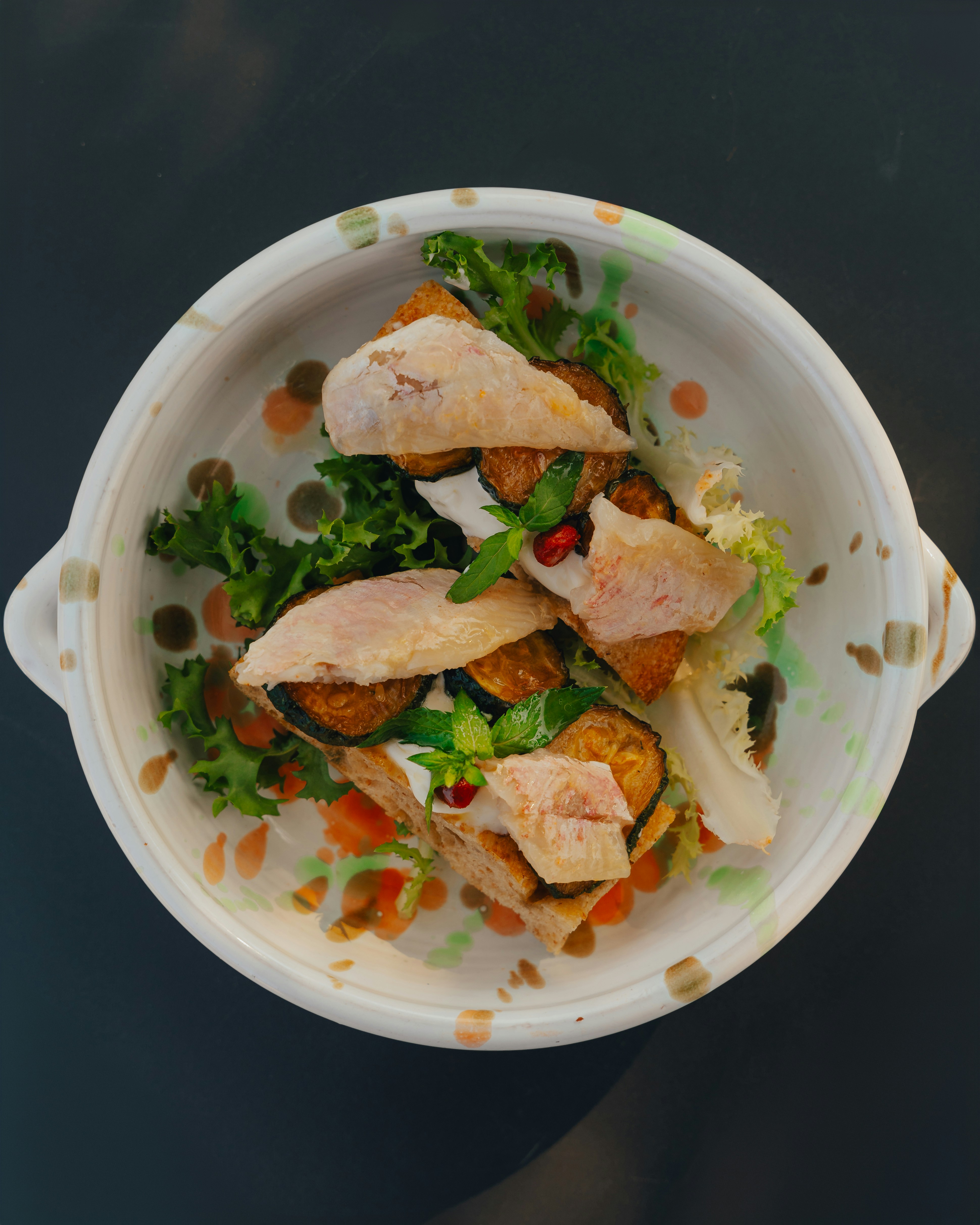 Citrus-kissed salmon atop herb-crisp croutons in a porcelain bowl