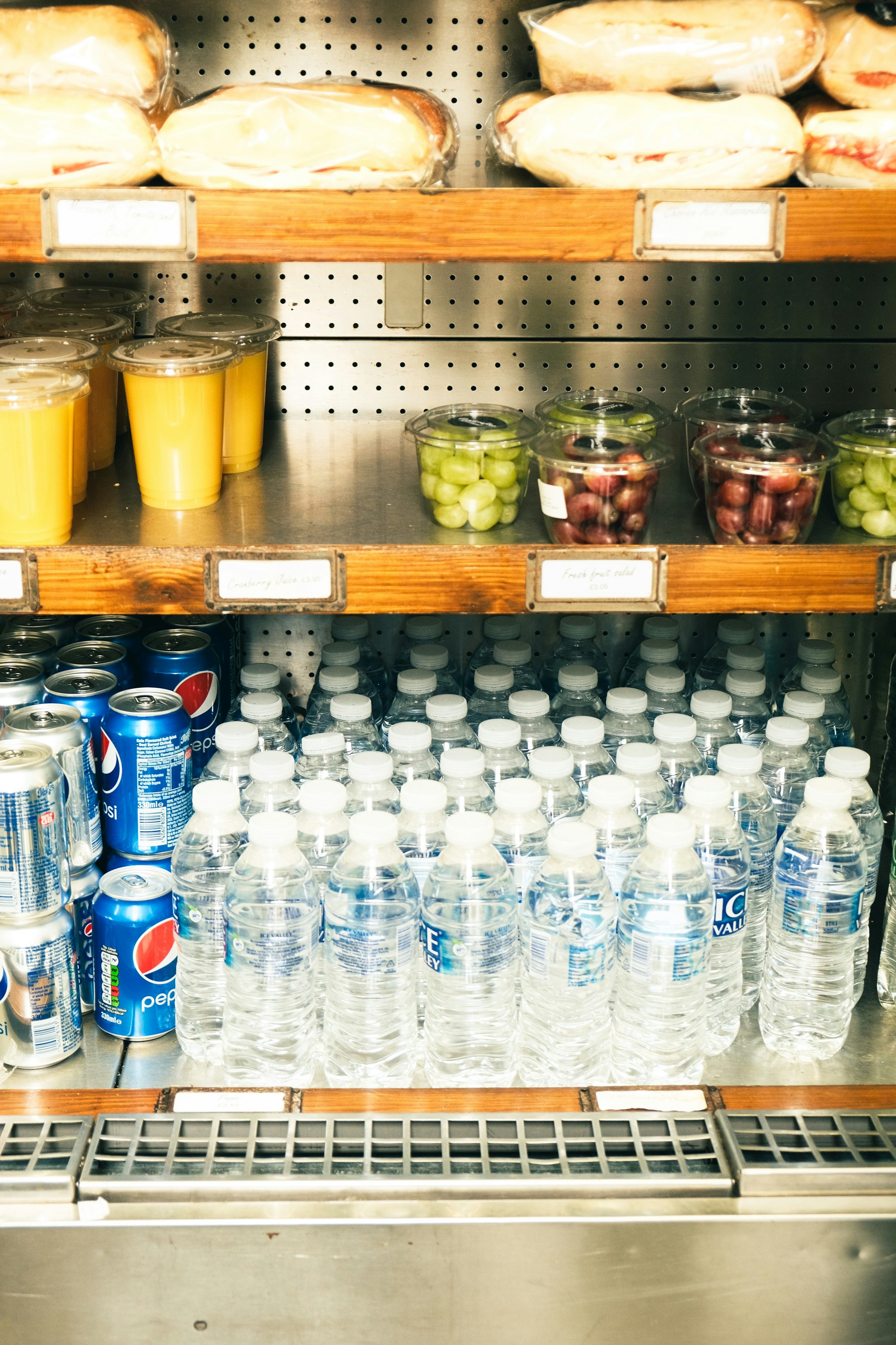 A store shelf filled with bottled water and fruit photo – Free Shop ...