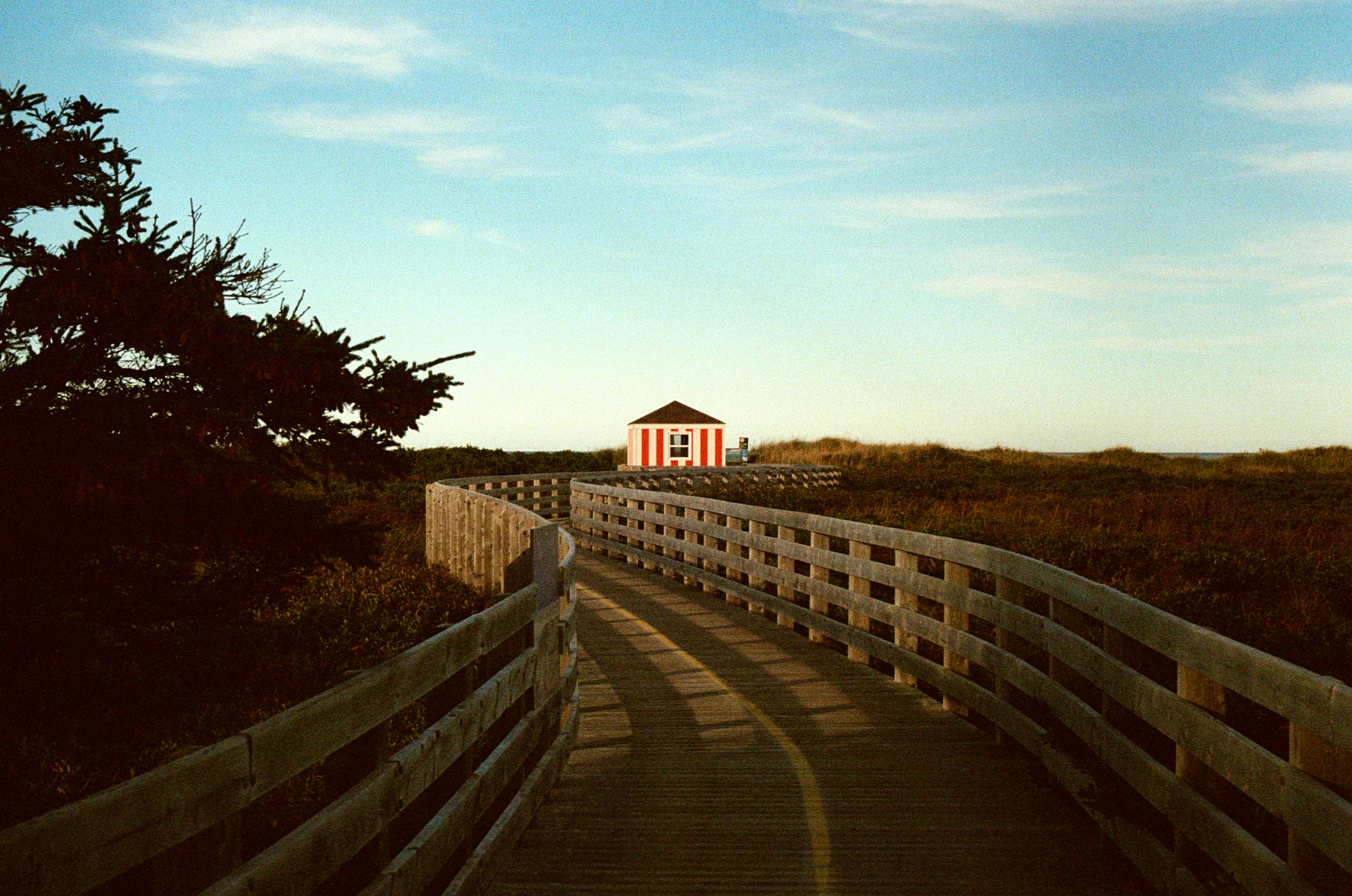 A wooden walkway leading to a small building