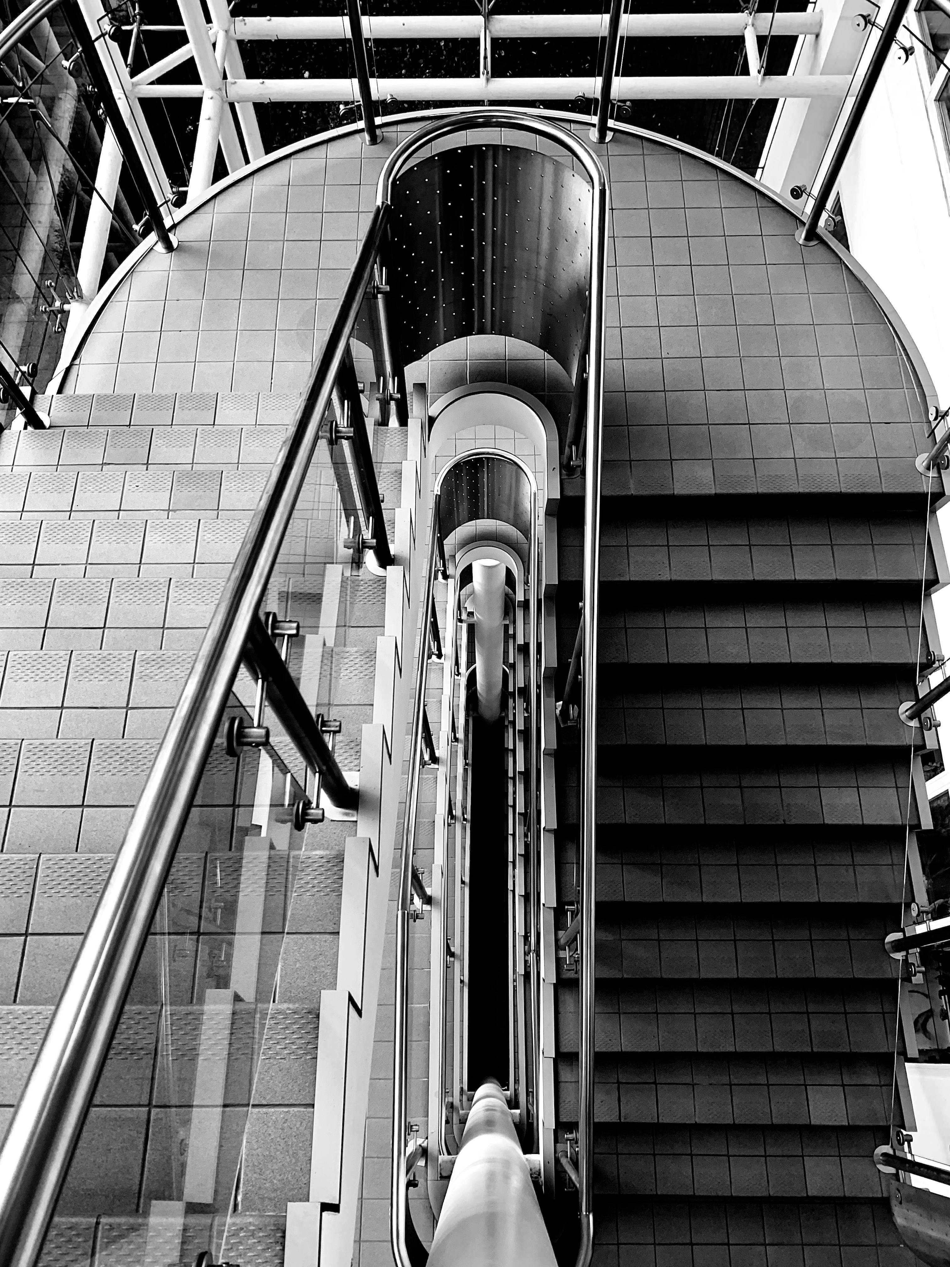 Convergence in Glass: A Monochrome Escalator Corridor