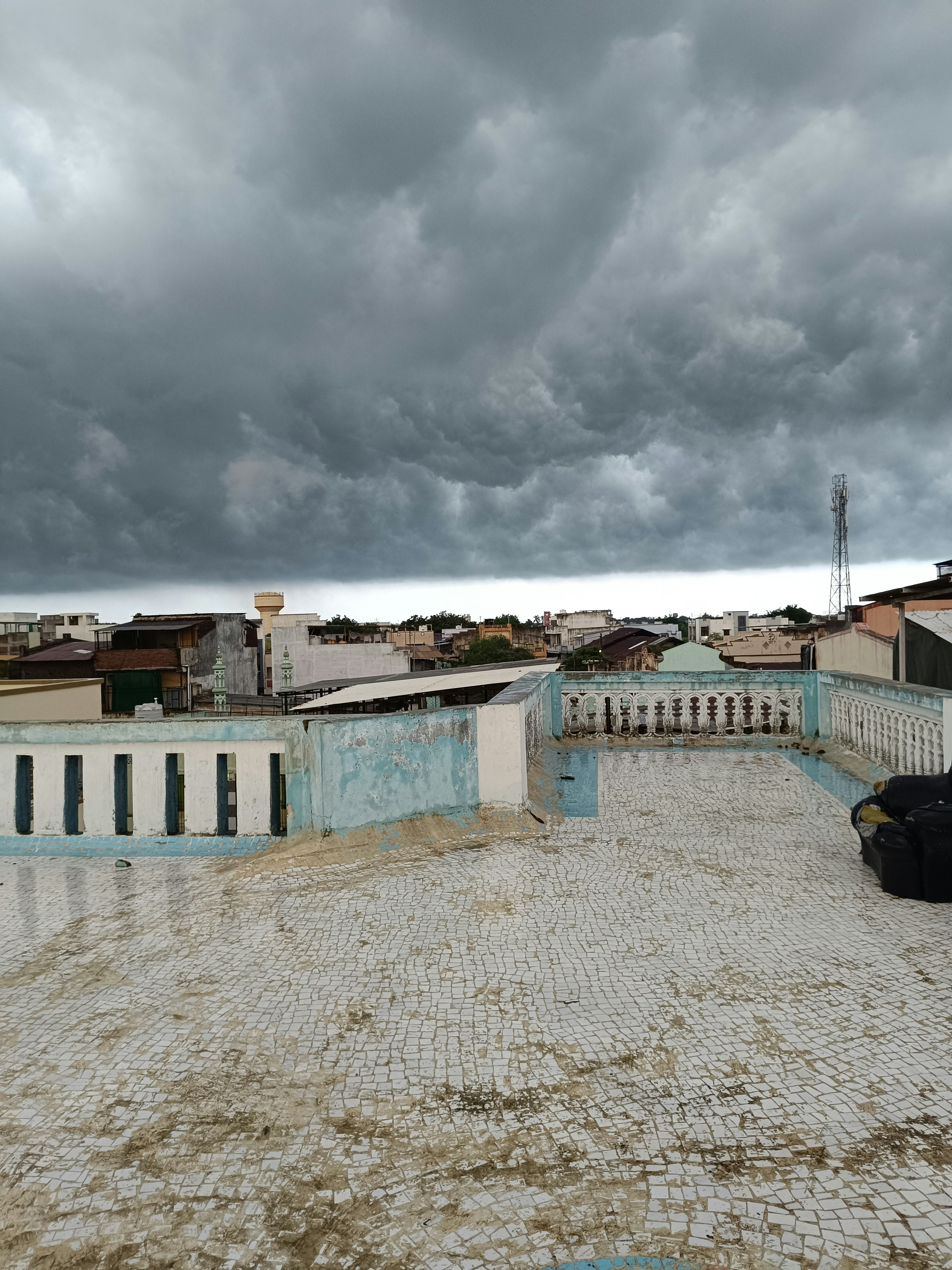 A black suitcase sitting on top of a roof photo – Free House Image on ...